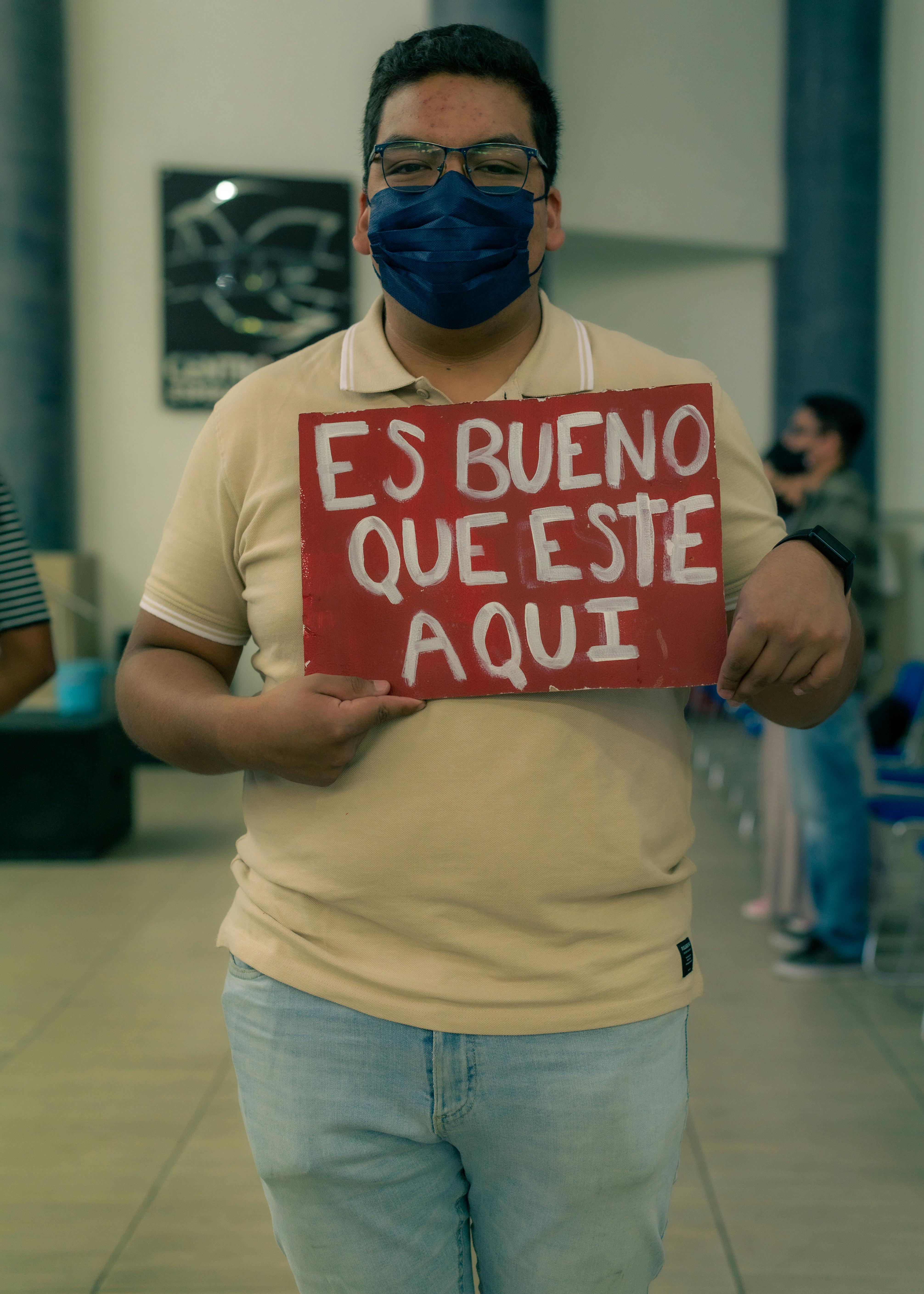 Man Standing on a Staircase Holding a Sign · Free Stock Photo