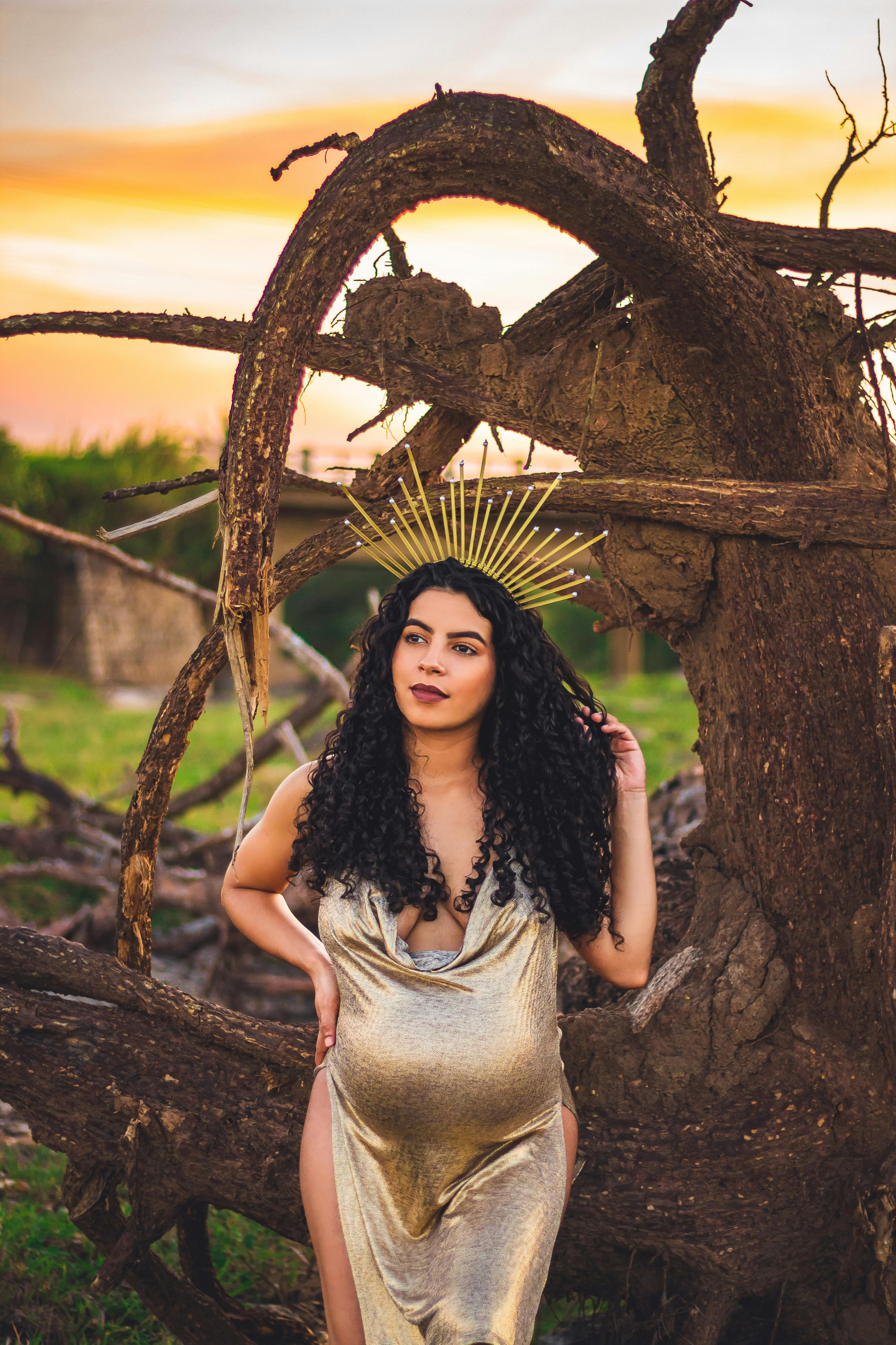 Pregnant Woman in Satin Dress Sitting on Tree Roots · Free Stock Photo