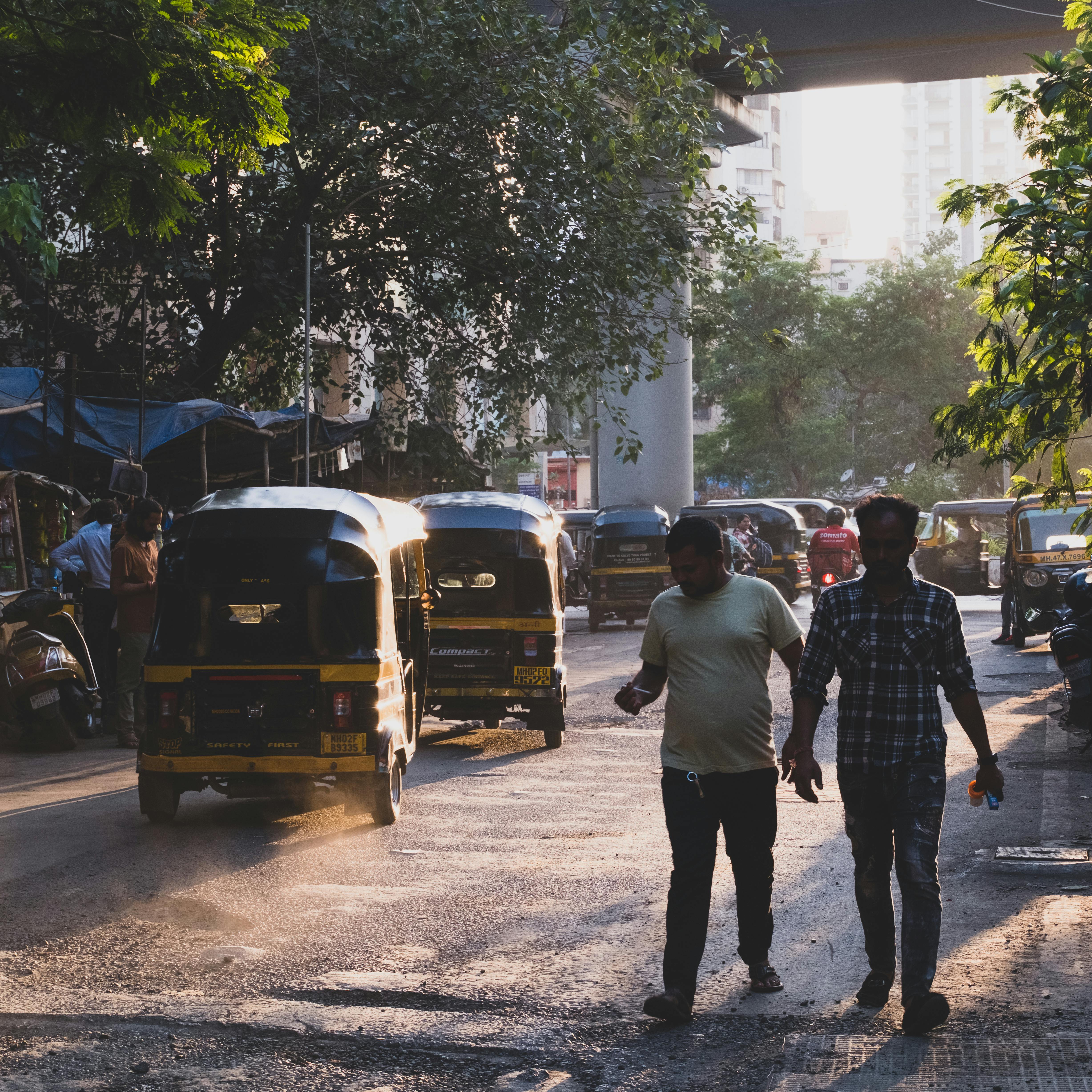 Men Walking on Street with Auto Rickshaws behind · Free Stock Photo