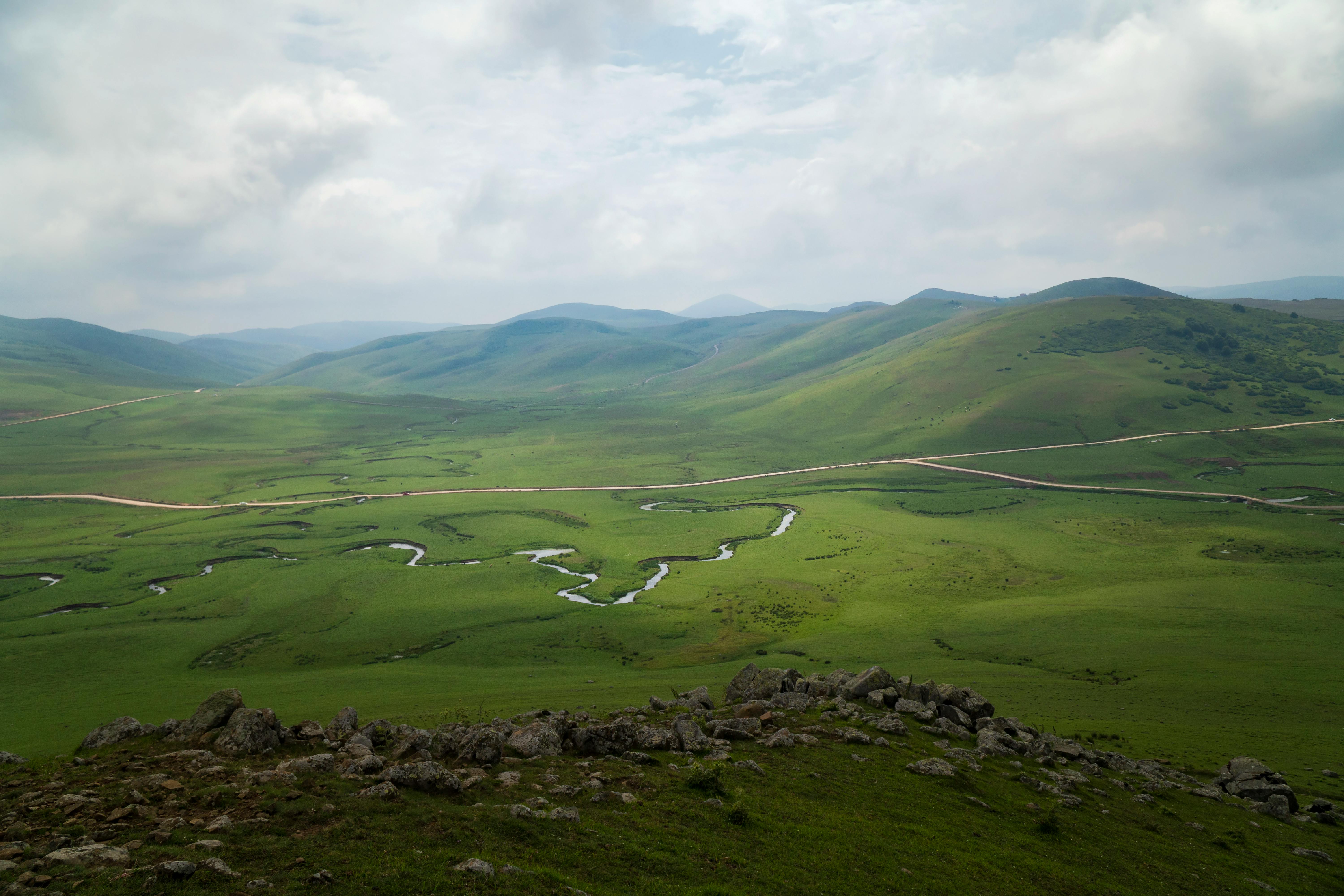 Meandering stream with mountains and clouds at The Persembe Plateau at ...