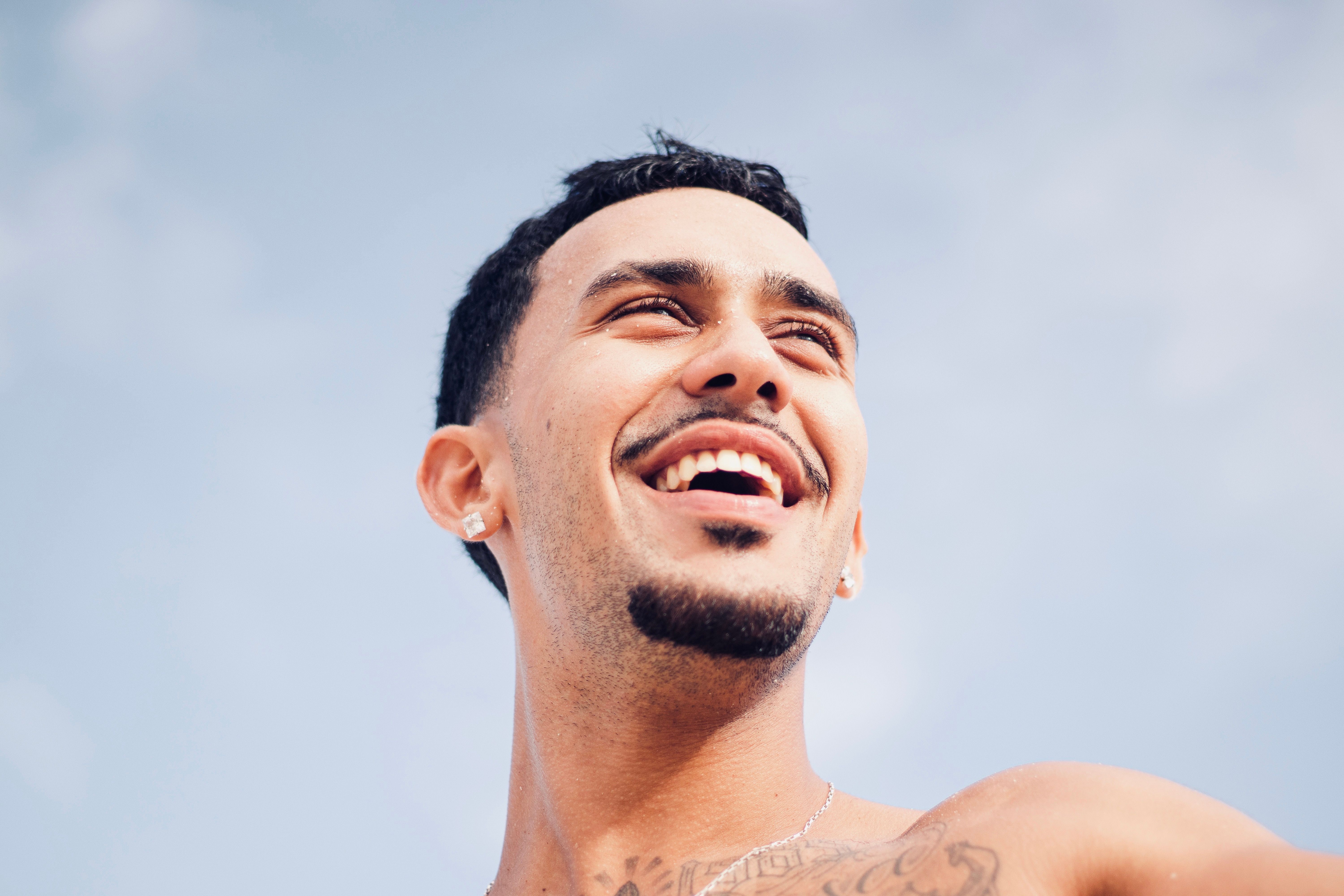 Low Angle Shot of a Shirtless Man Smiling Outdoors · Free Stock Photo