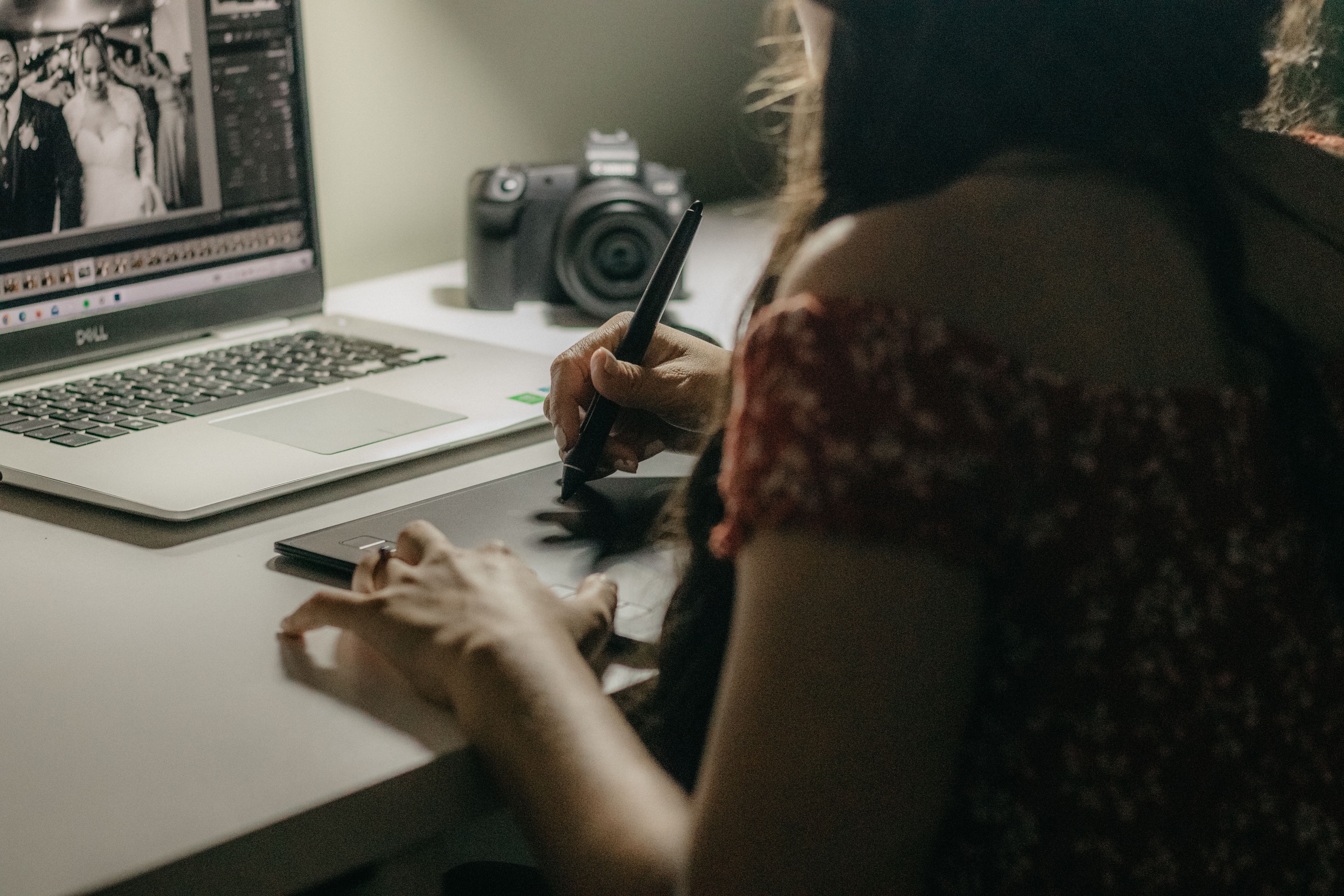 A woman is using a laptop to take pictures · Free Stock Photo