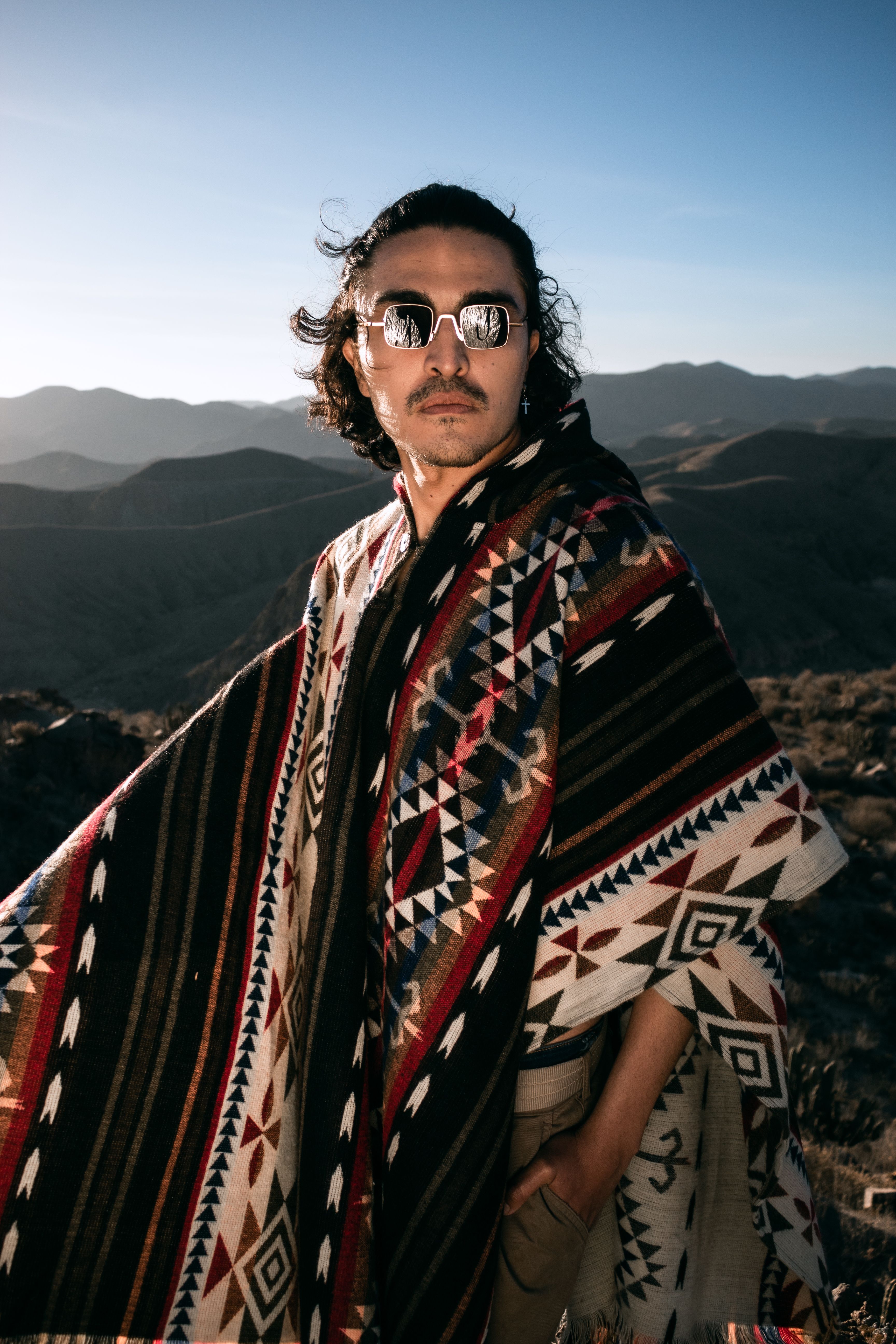 Man Wearing a Poncho with a Pattern and Sunglasses · Free Stock Photo
