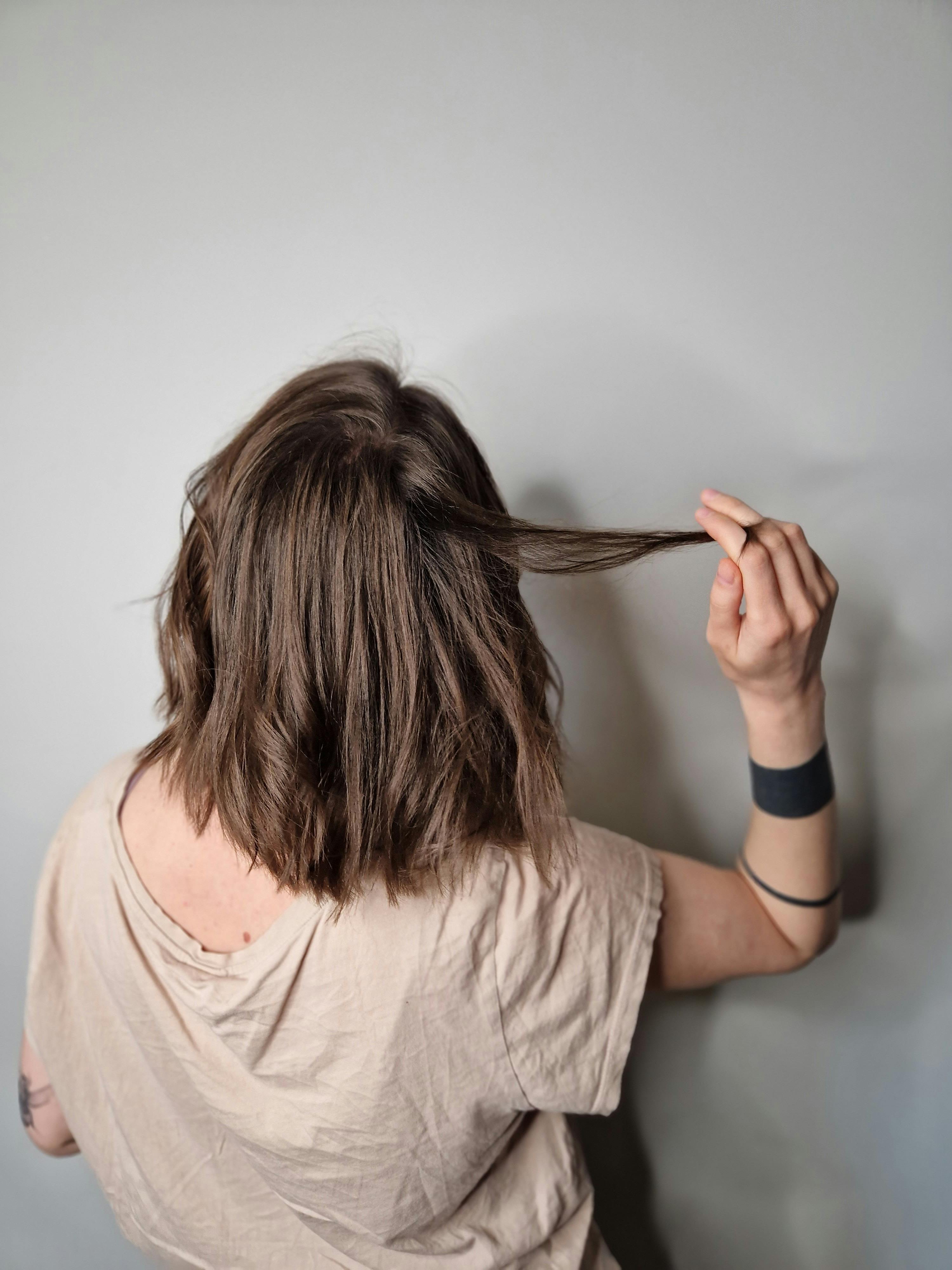 A Young Person with an Arm Tattoo Leaning on the Railing on a Pier ...