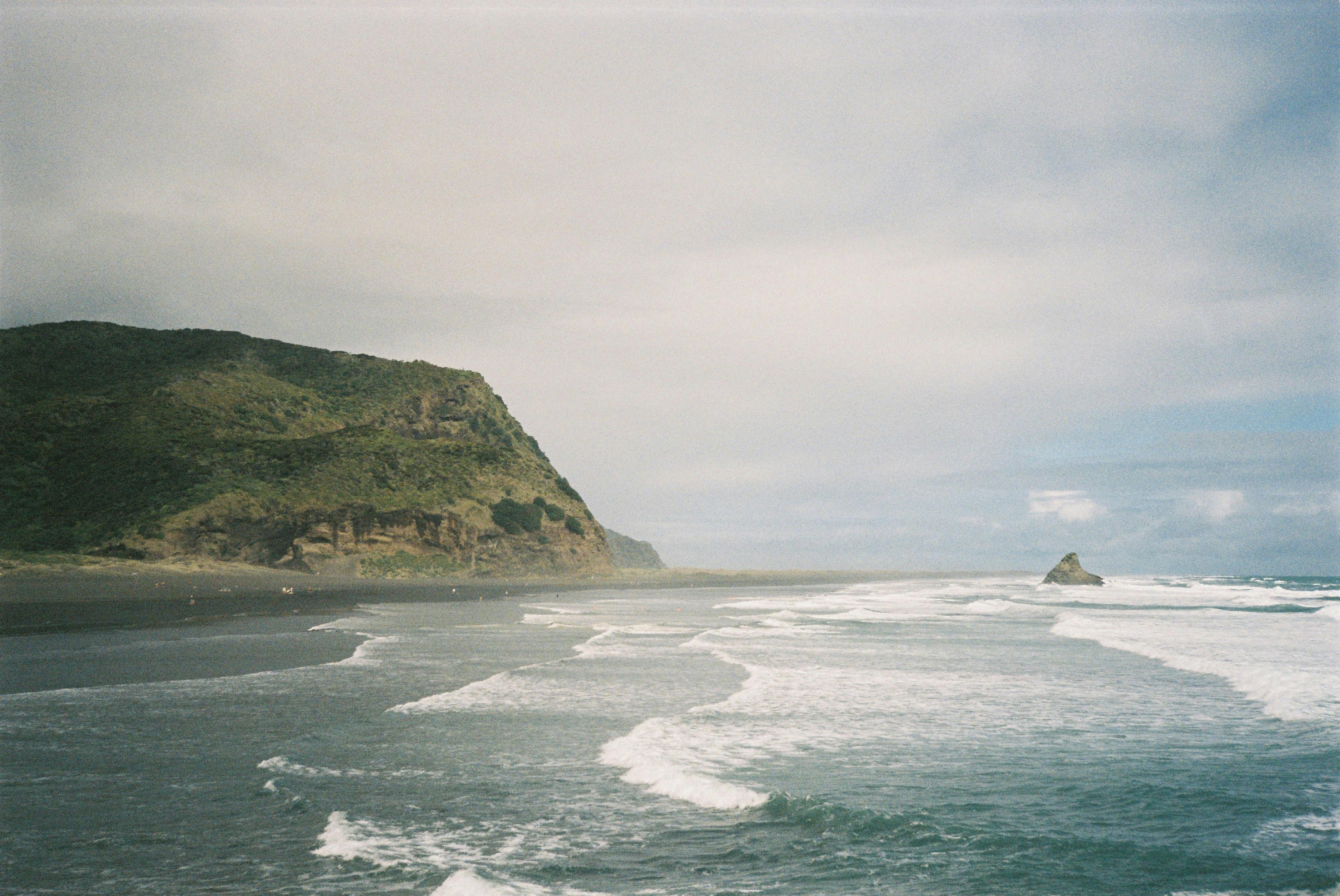 Scenic Coastline with Long Low Waves and Green Cliff · Free Stock Photo