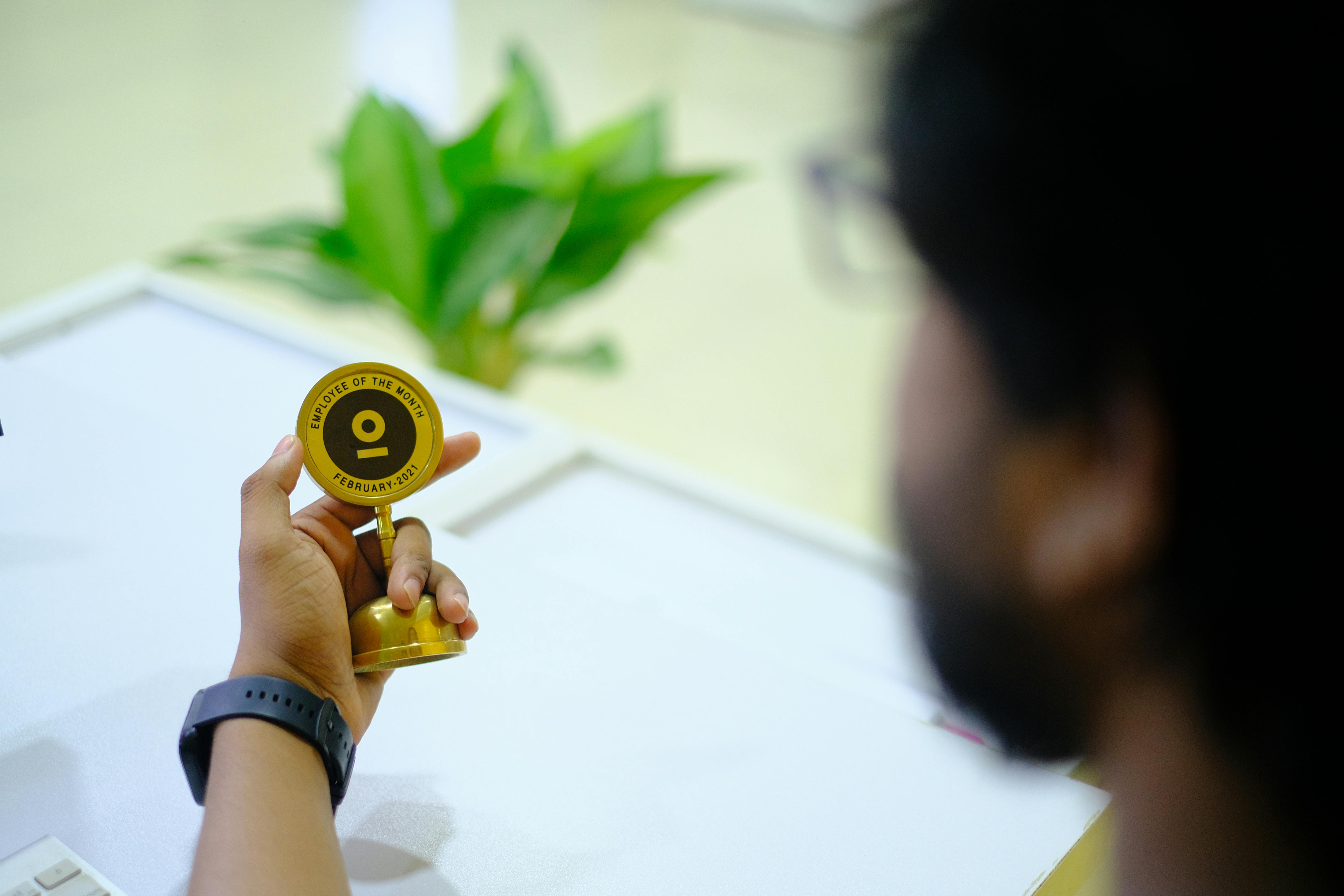 Close-up of Man Holding Golden Award in Hand · Free Stock Photo