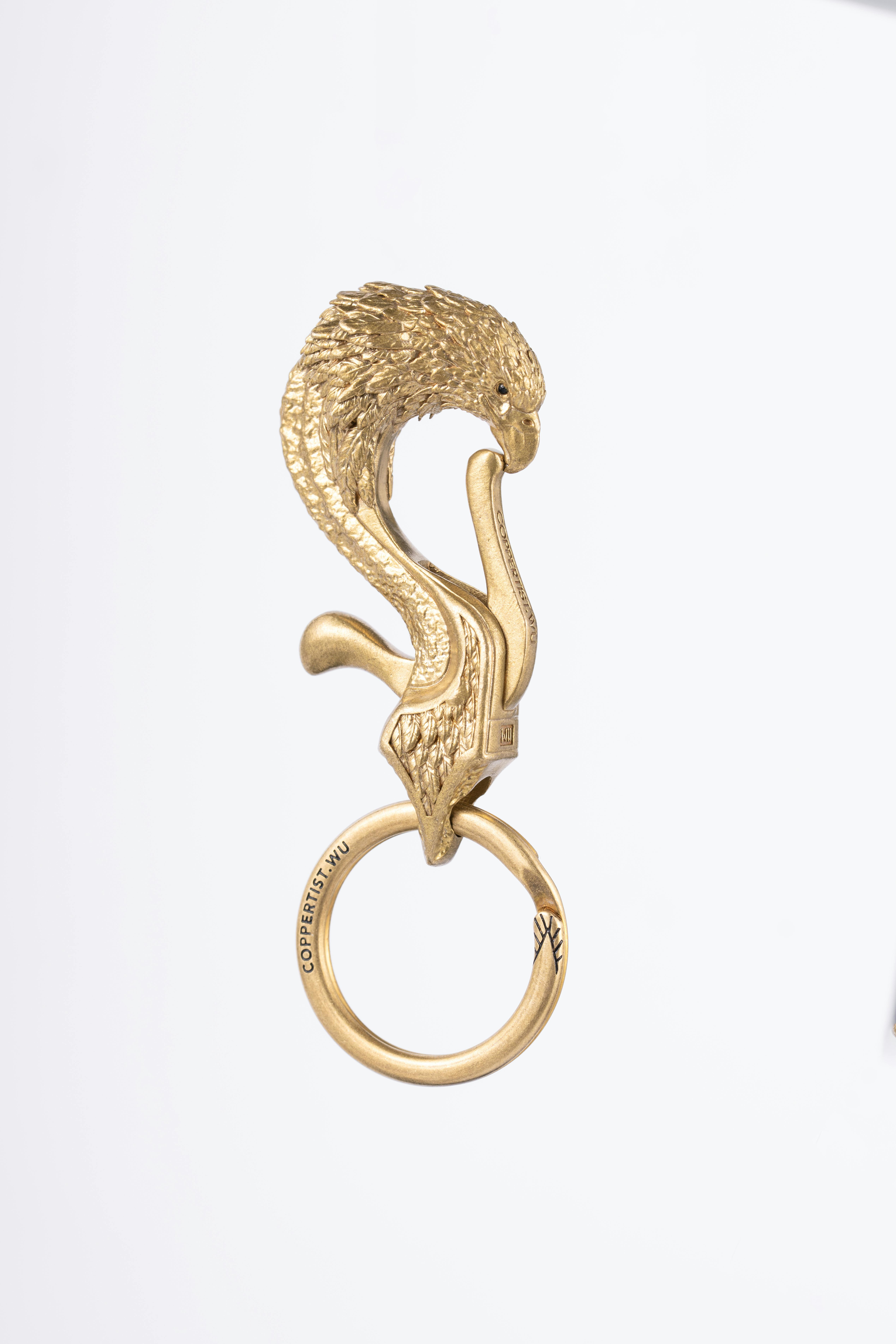 Golden Keychain on White Background · Free Stock Photo