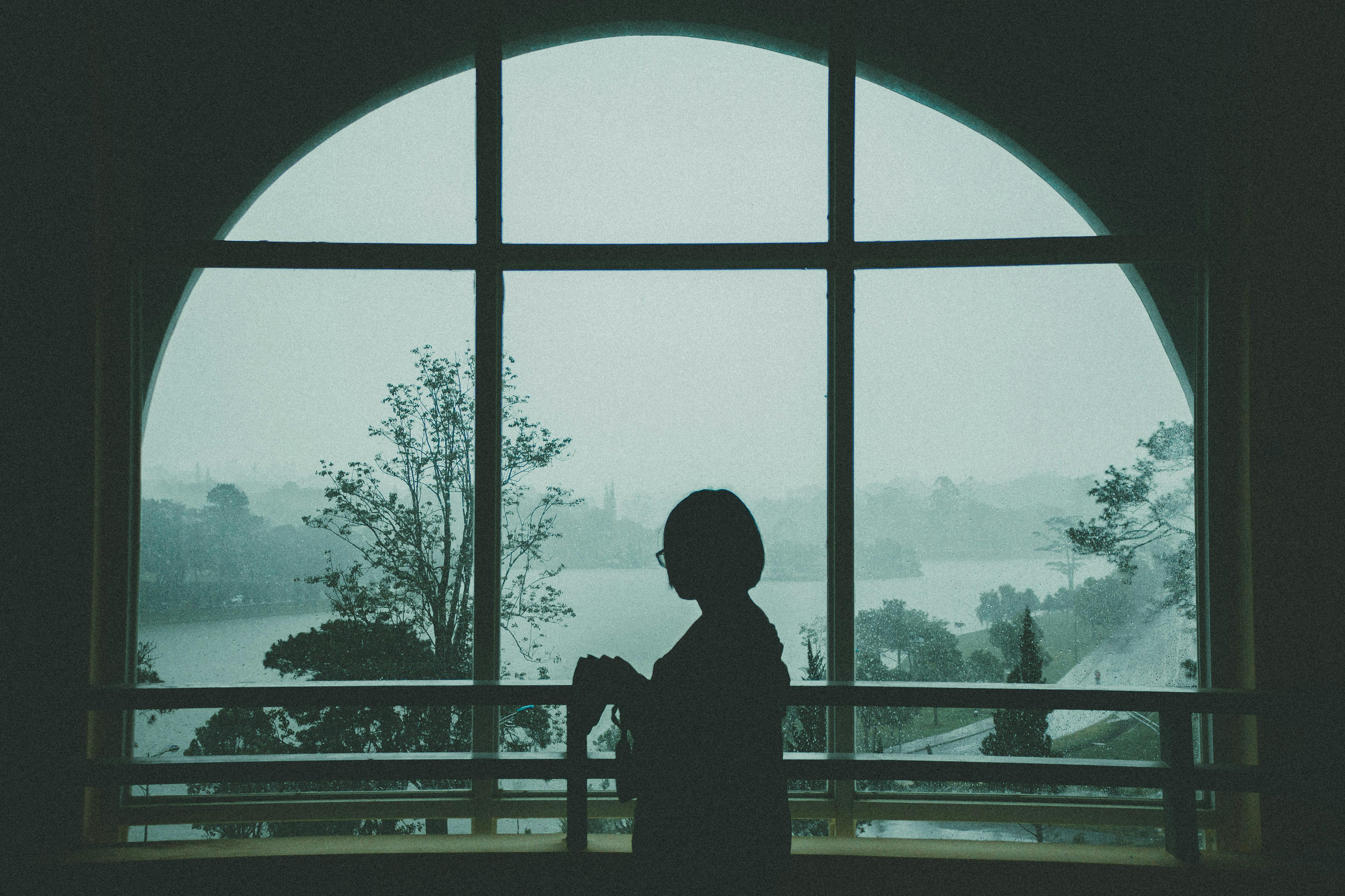 Woman Standing Beside Window · Free Stock Photo