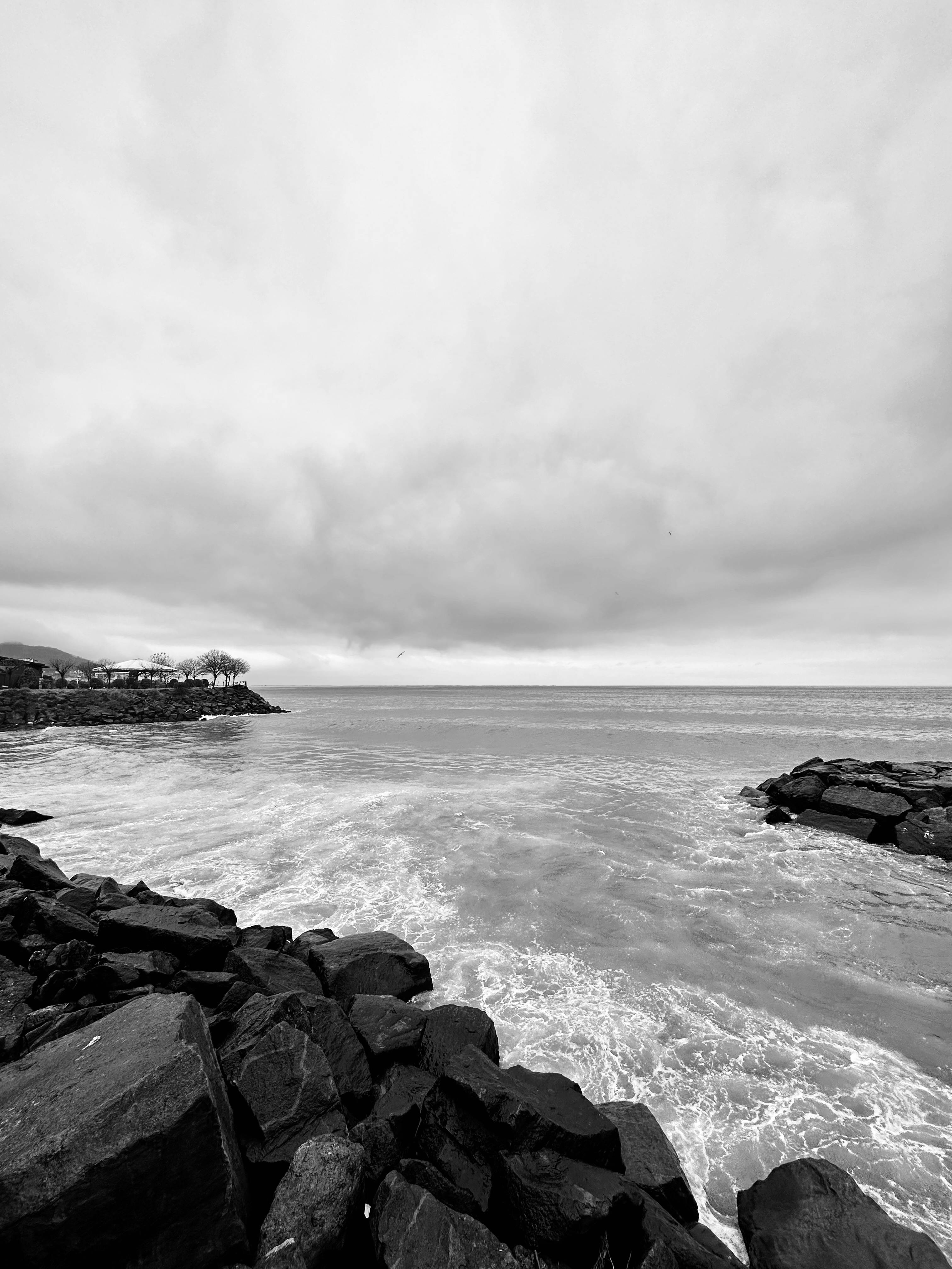 Wide Angle Rough Seascape with Black Stones on a Shore · Free Stock Photo