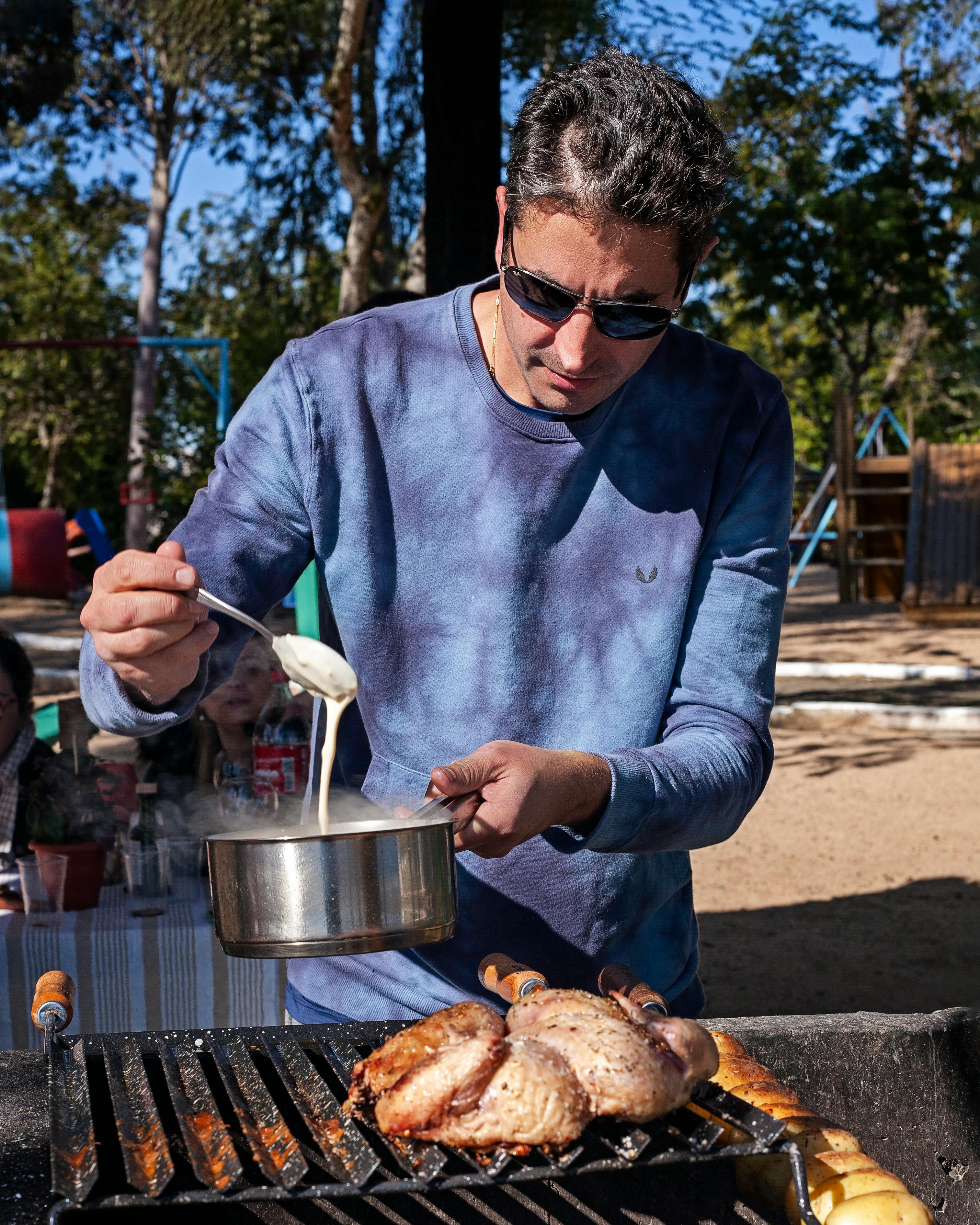 Man Holding Pot over Barbecue · Free Stock Photo