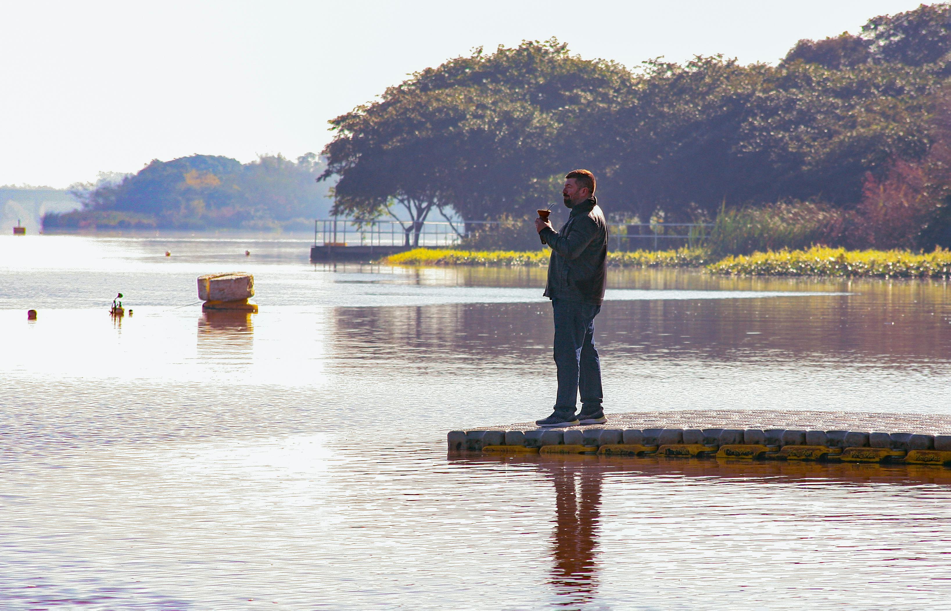 Photo of a Man Standing on a Wooden Pier · Free Stock Photo