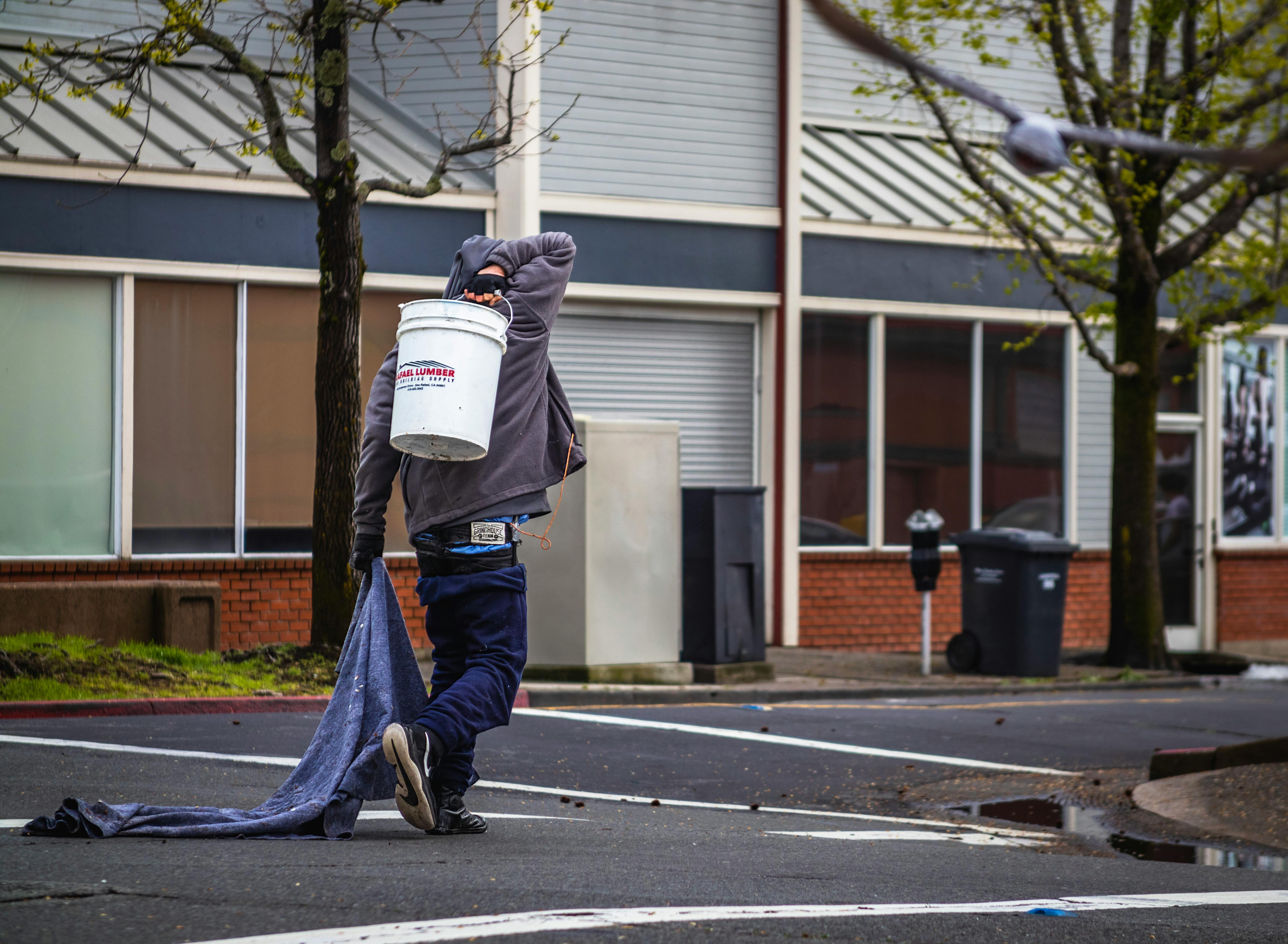 Man Walking with Bucket on Street · Free Stock Photo