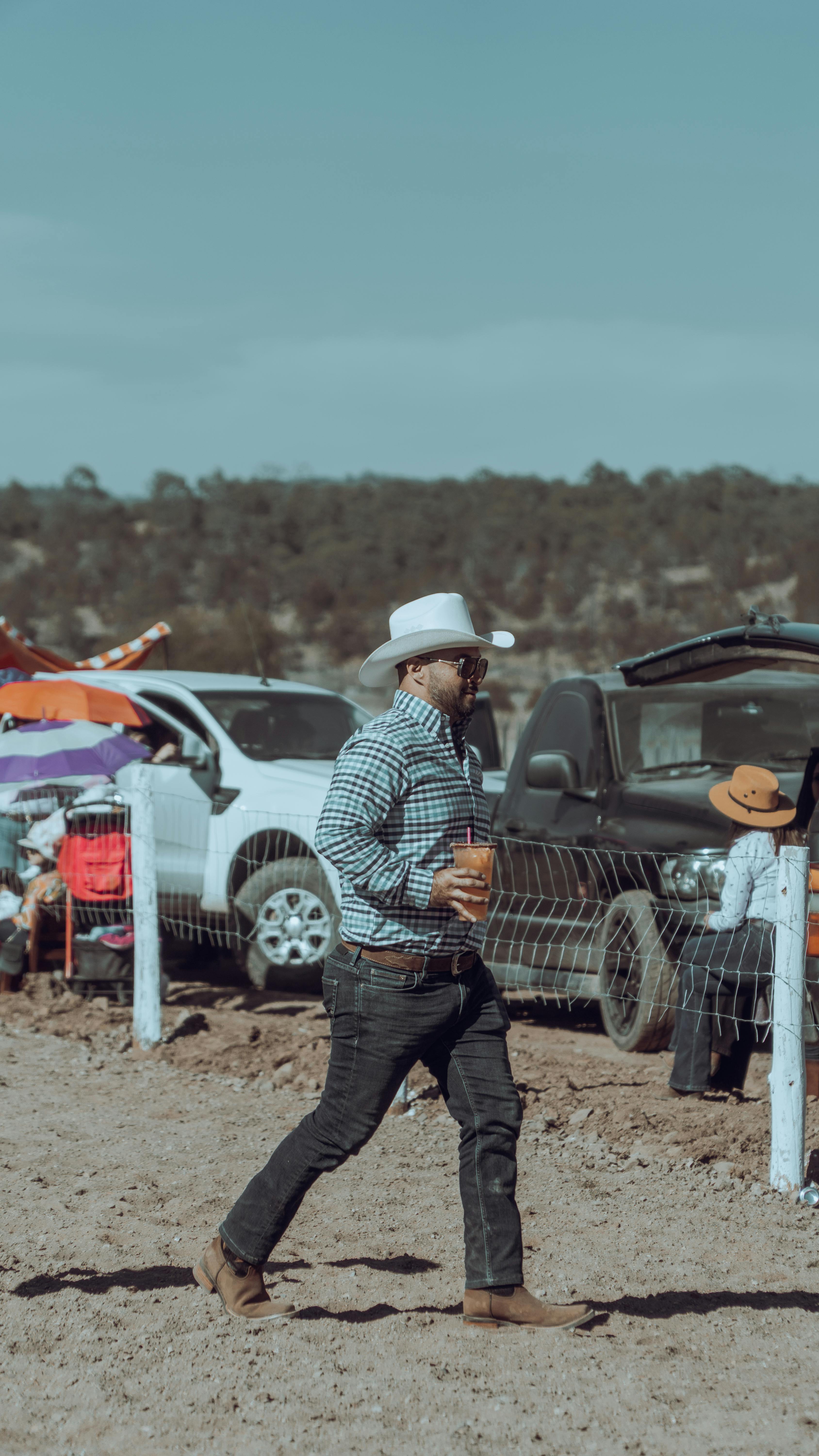 Photo of a Cowboy in a Pasture with a Rocky Mountain in the Background ...
