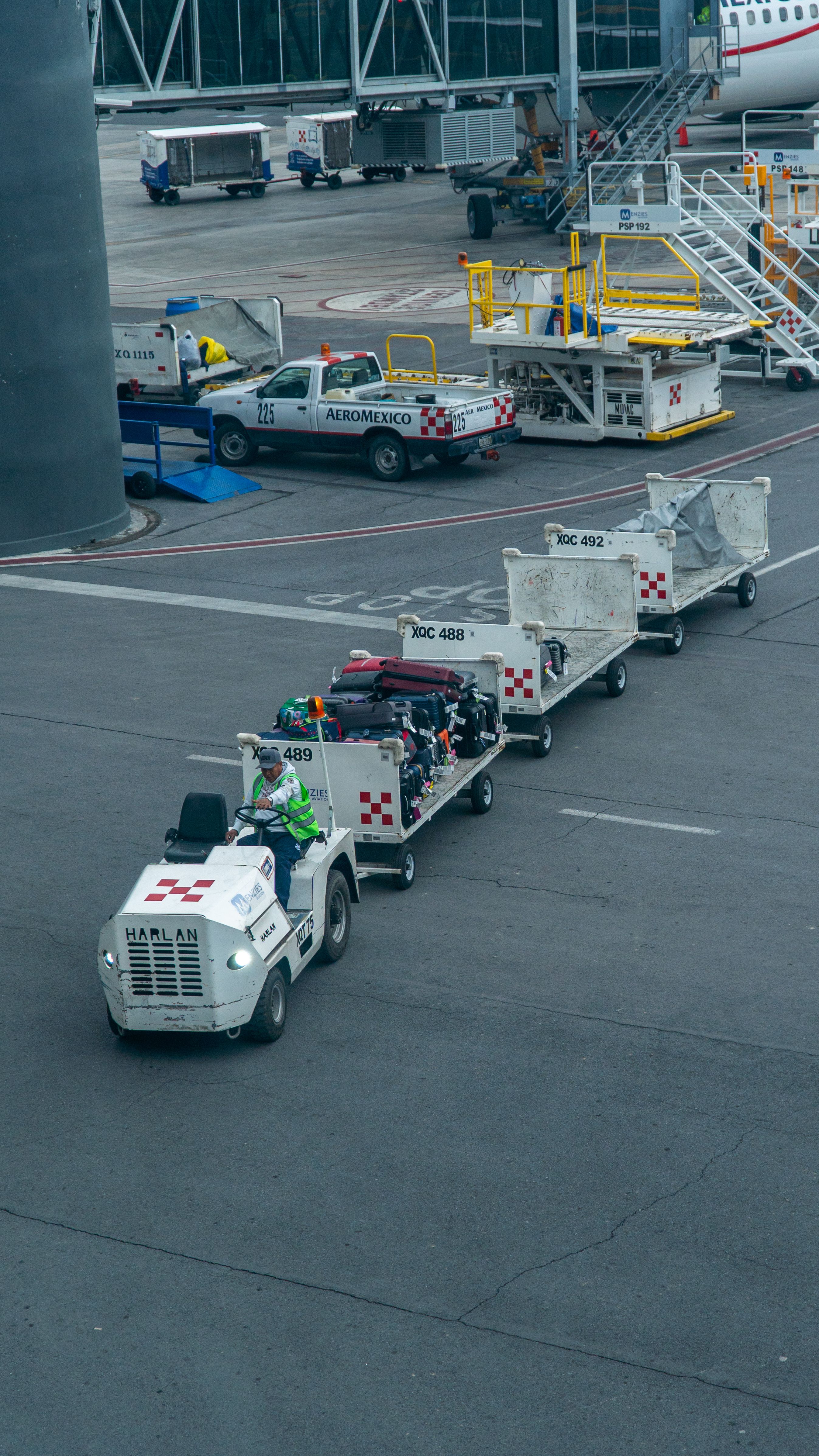Ground Crew Member Driving Vehicle with Baggage · Free Stock Photo