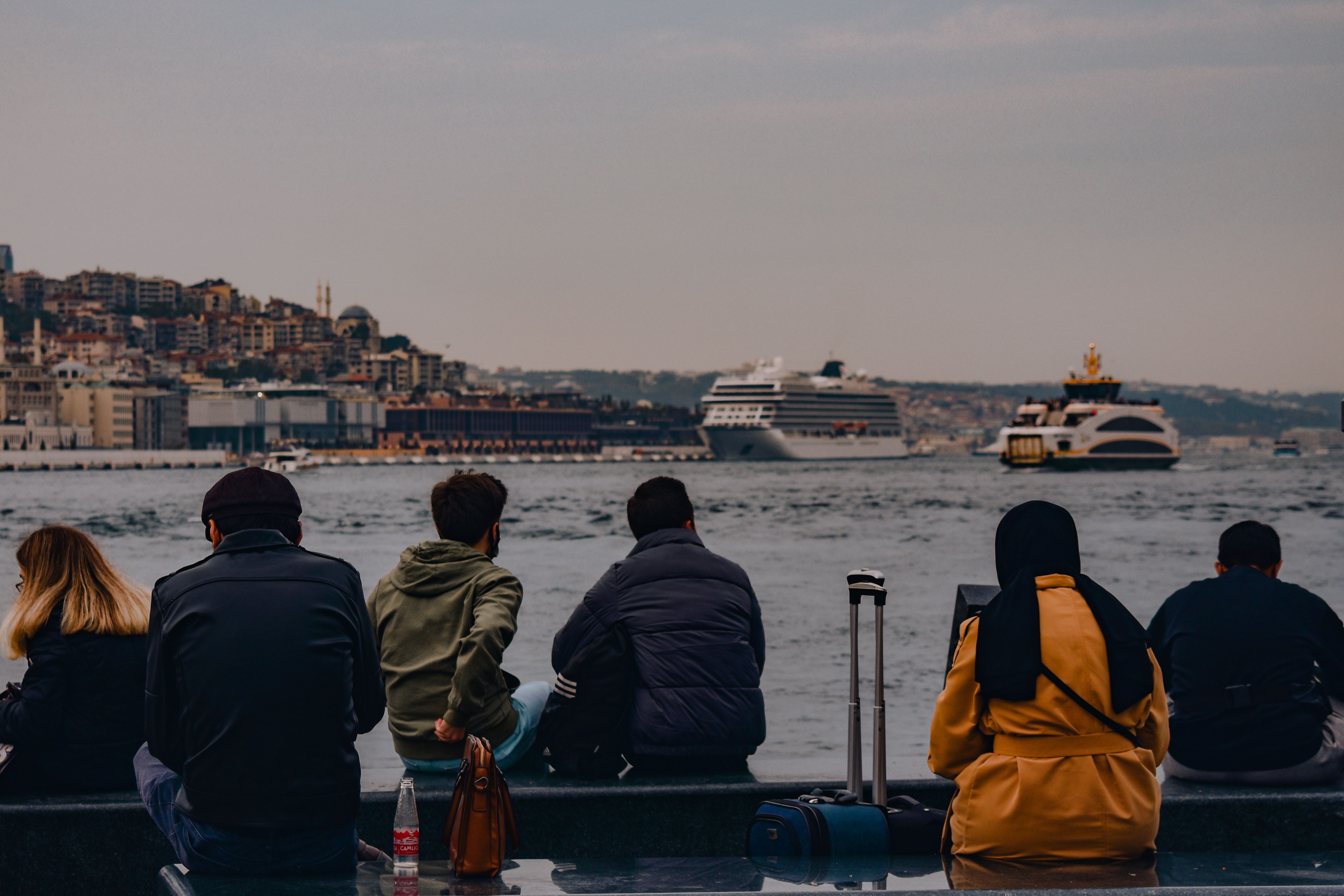 People sitting on a dock watching boats go by · Free Stock Photo