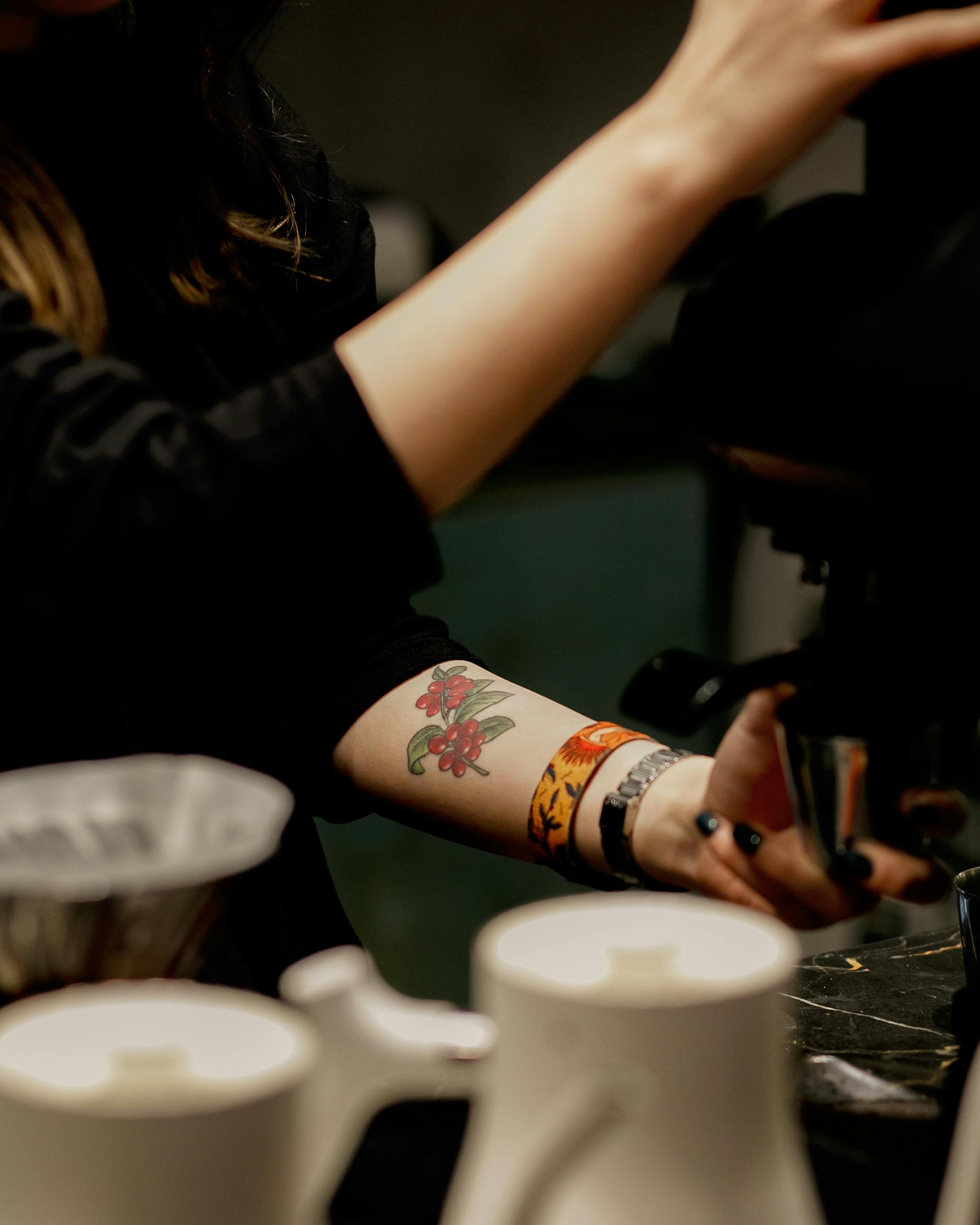 Barista with a Tattoo Using a Coffee Machine · Free Stock Photo