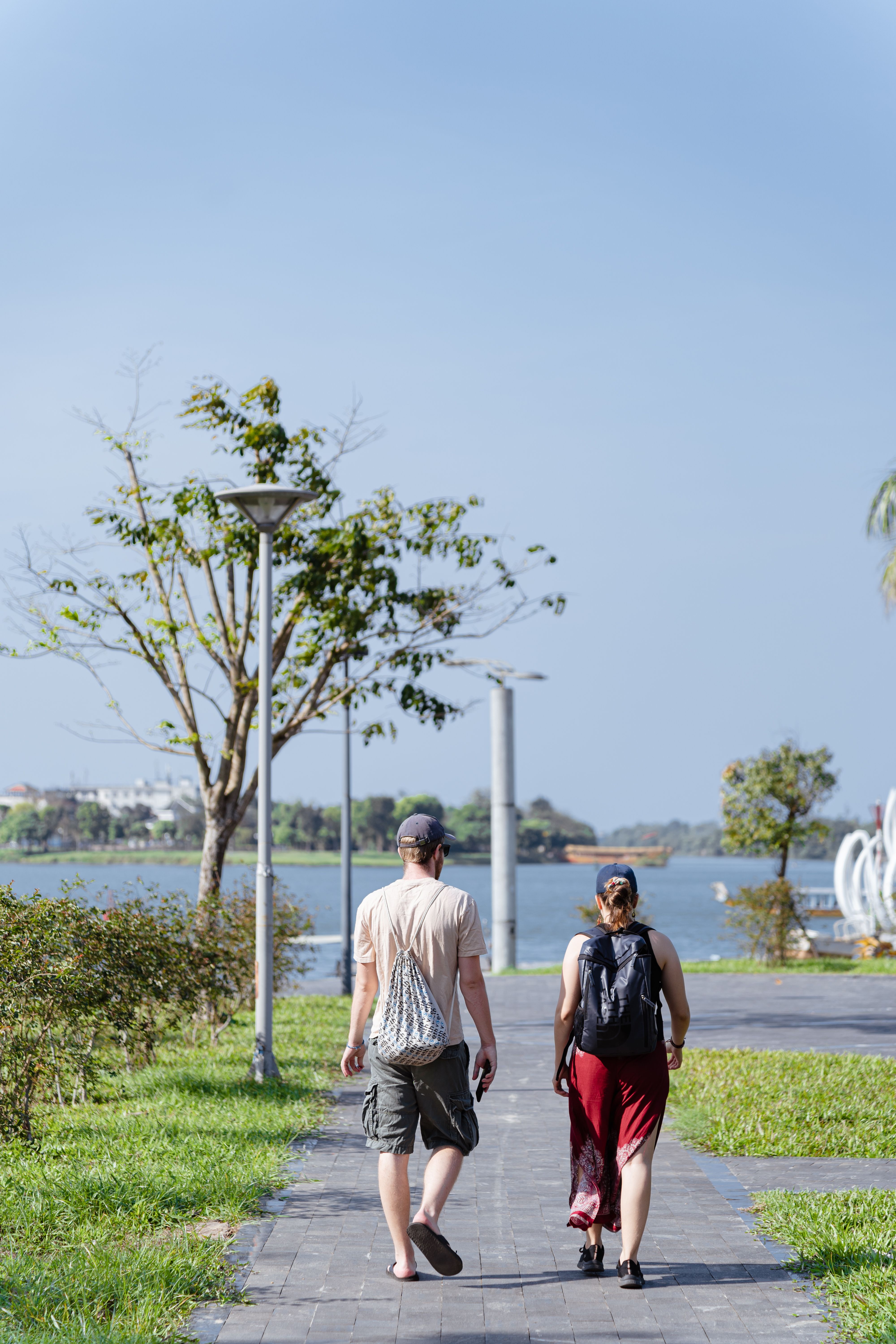 People with Backpacks Walking on Boardwalk · Free Stock Photo