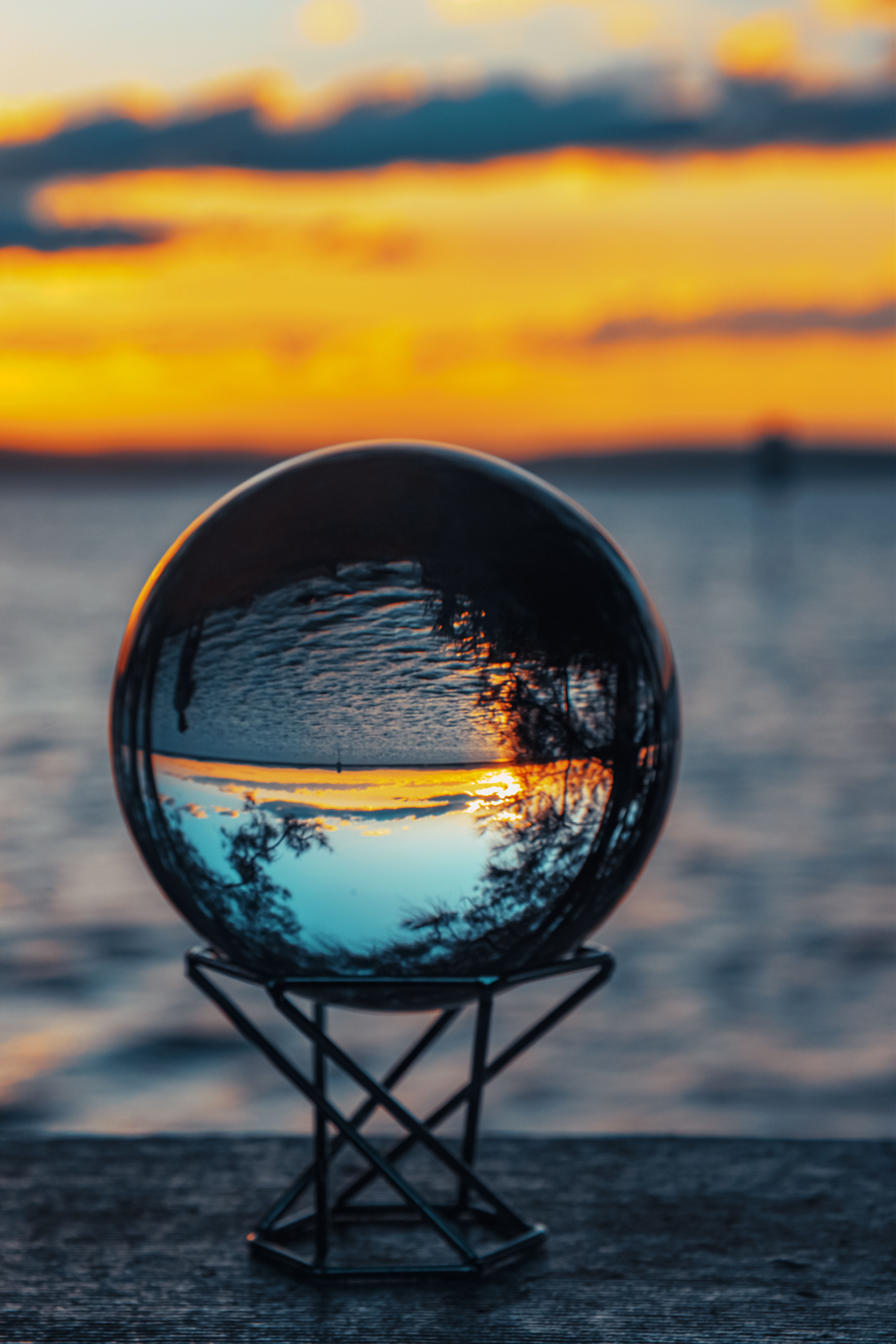 A glass ball with a sunset in the background · Free Stock Photo