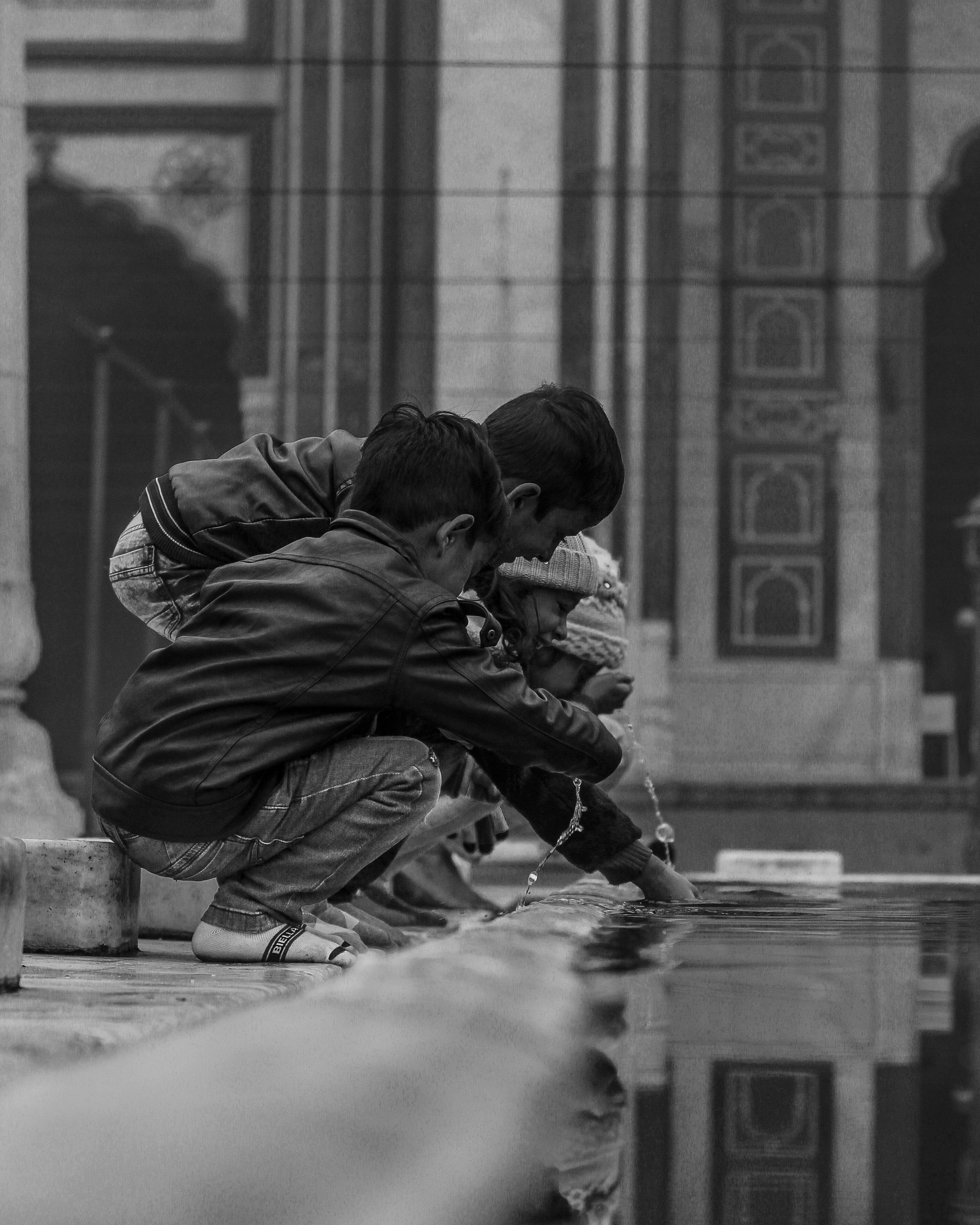 Children Crouching by the Fountain · Free Stock Photo