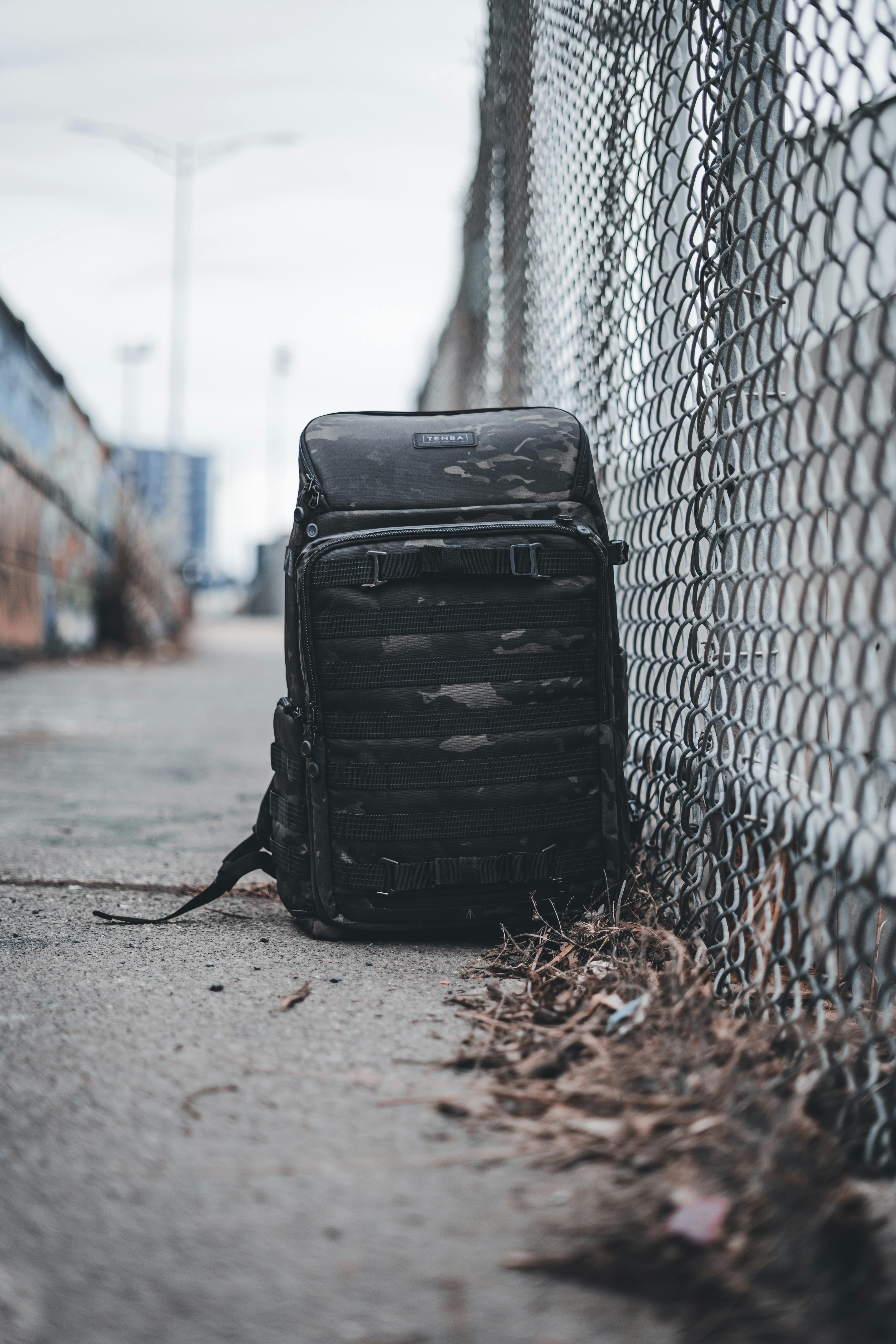 Backpack by Wire Mesh Fence · Free Stock Photo