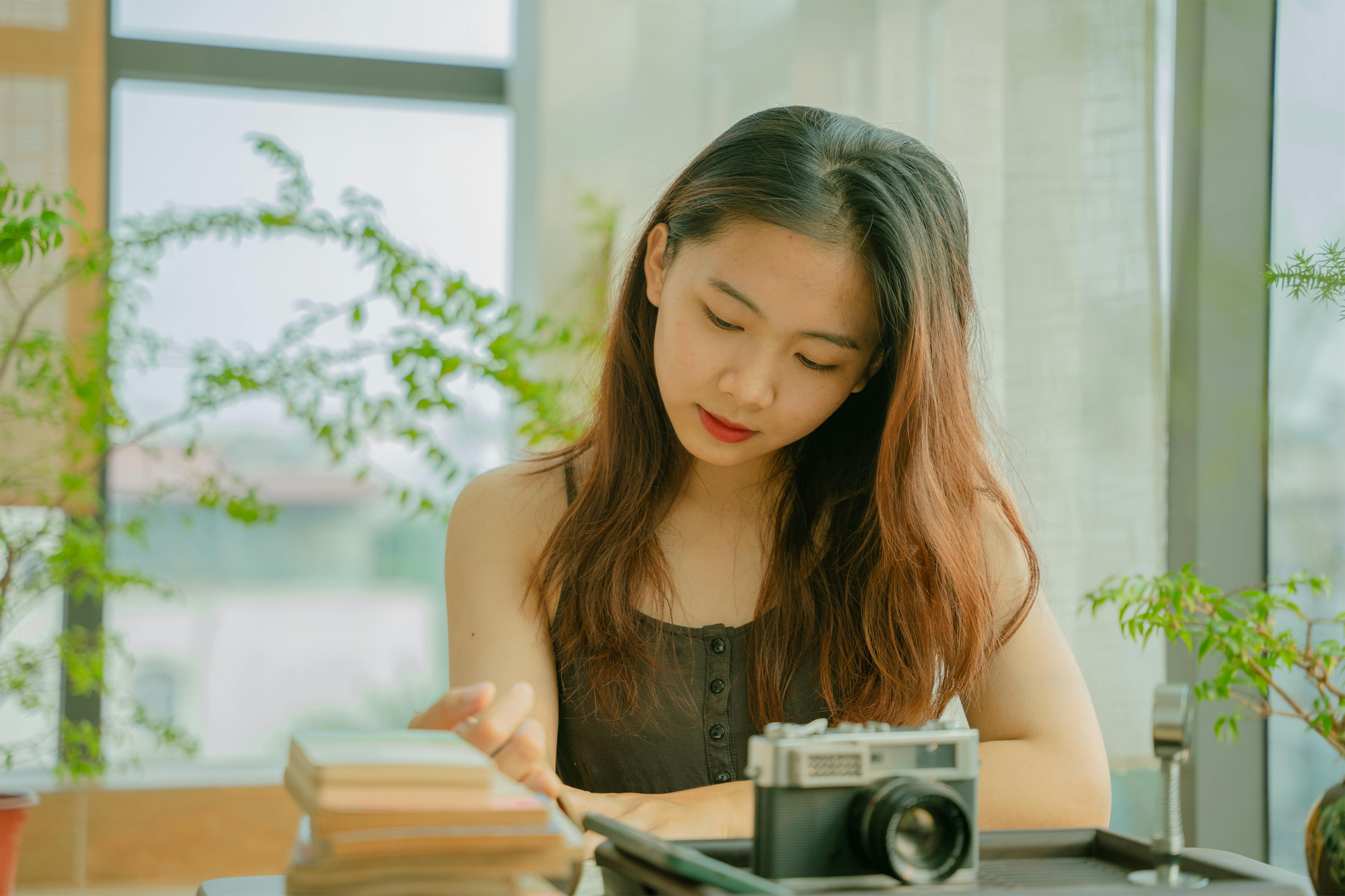 Girl Sitting at Desk with Retro Camera · Free Stock Photo