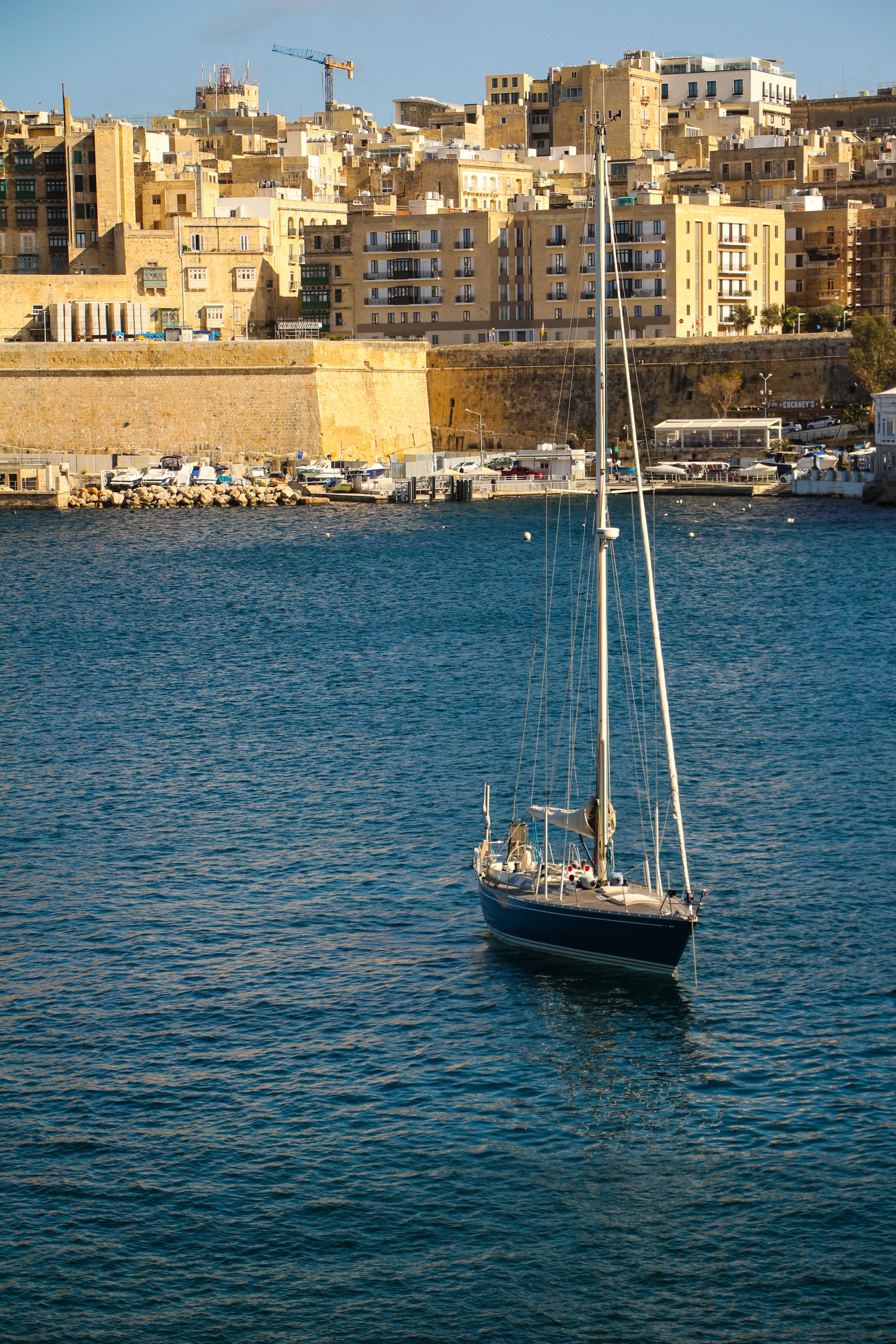 Sailboat on Sea Coast in Town · Free Stock Photo