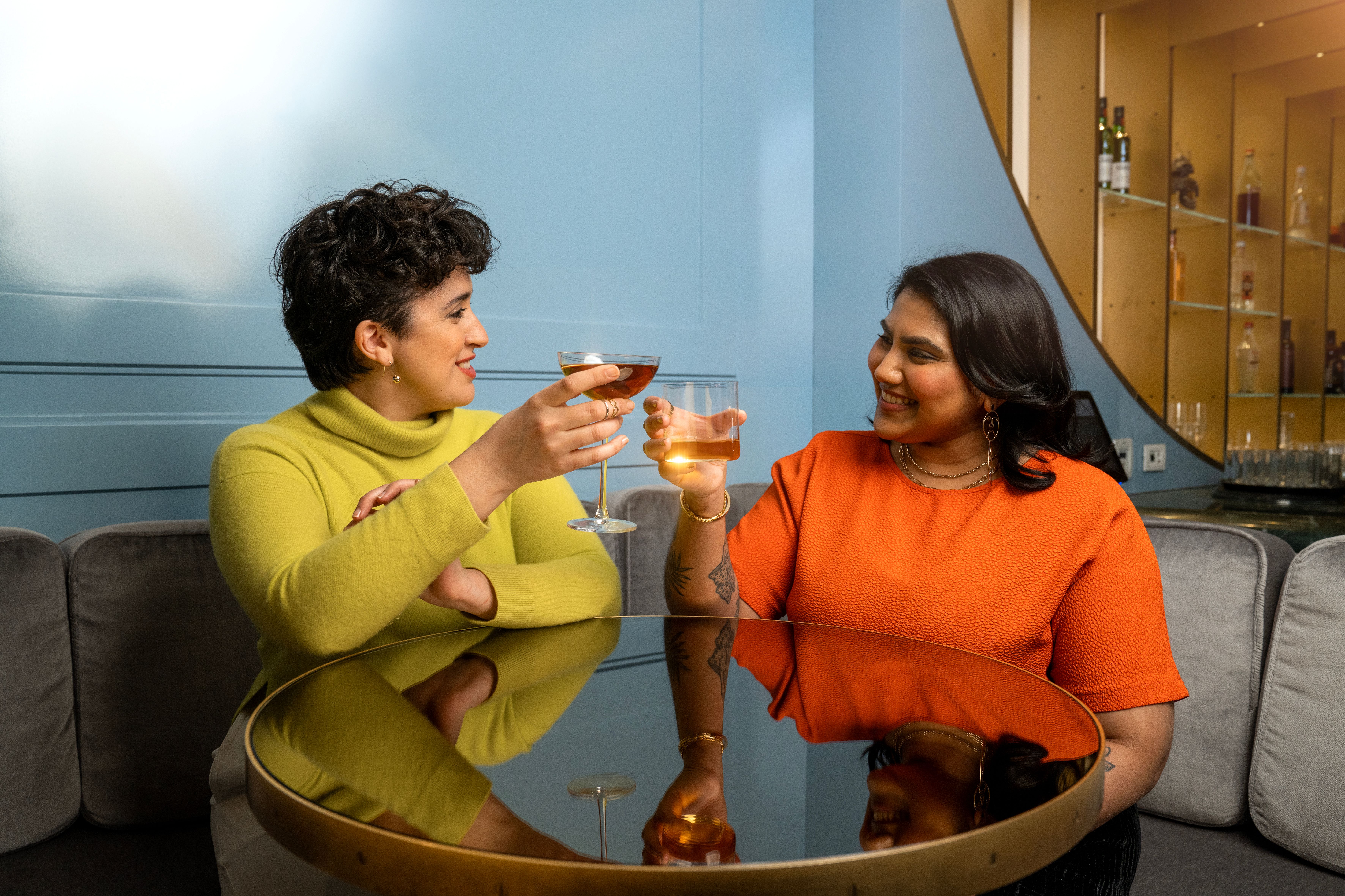Two Women Toasting at a Shiny Table · Free Stock Photo