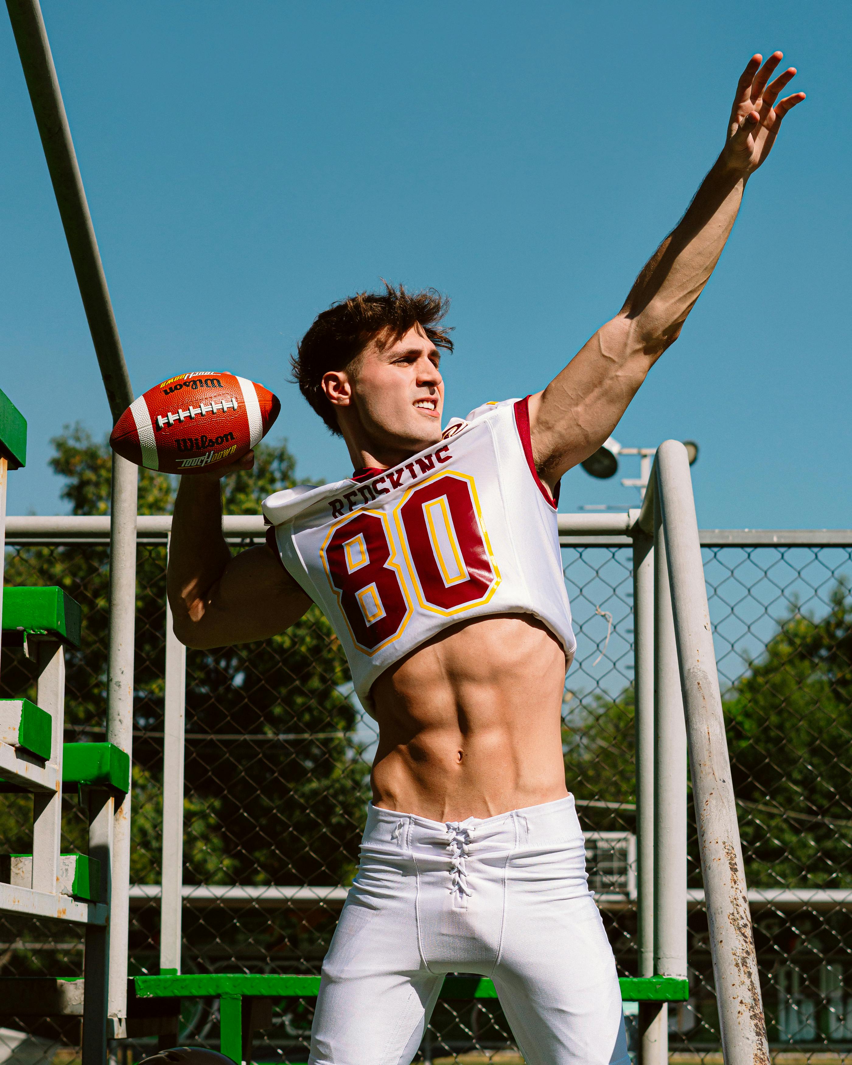 Portrait of a Muscular American Football Player Posing with a Football ...