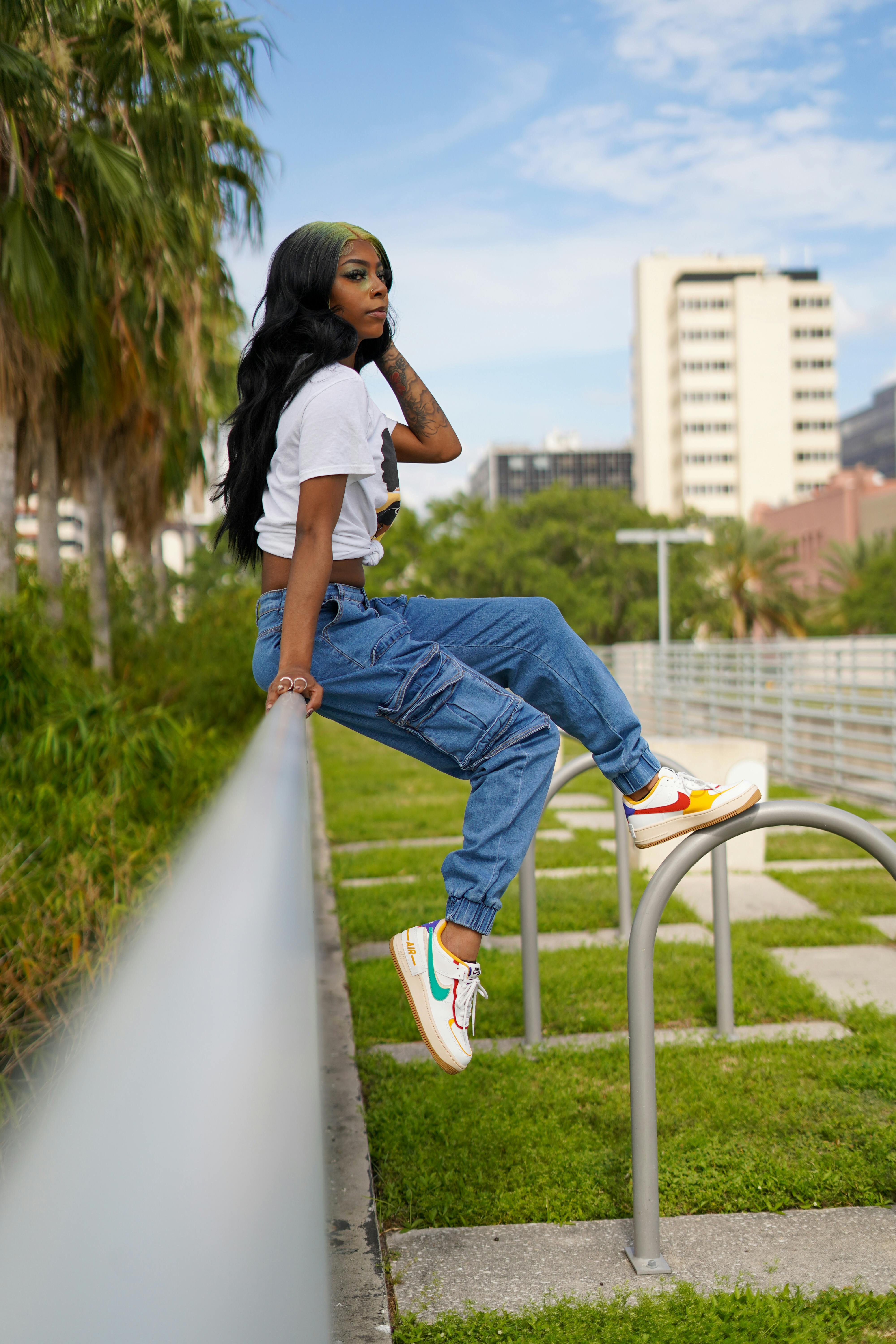 Woman Sitting on Railing and Posing · Free Stock Photo