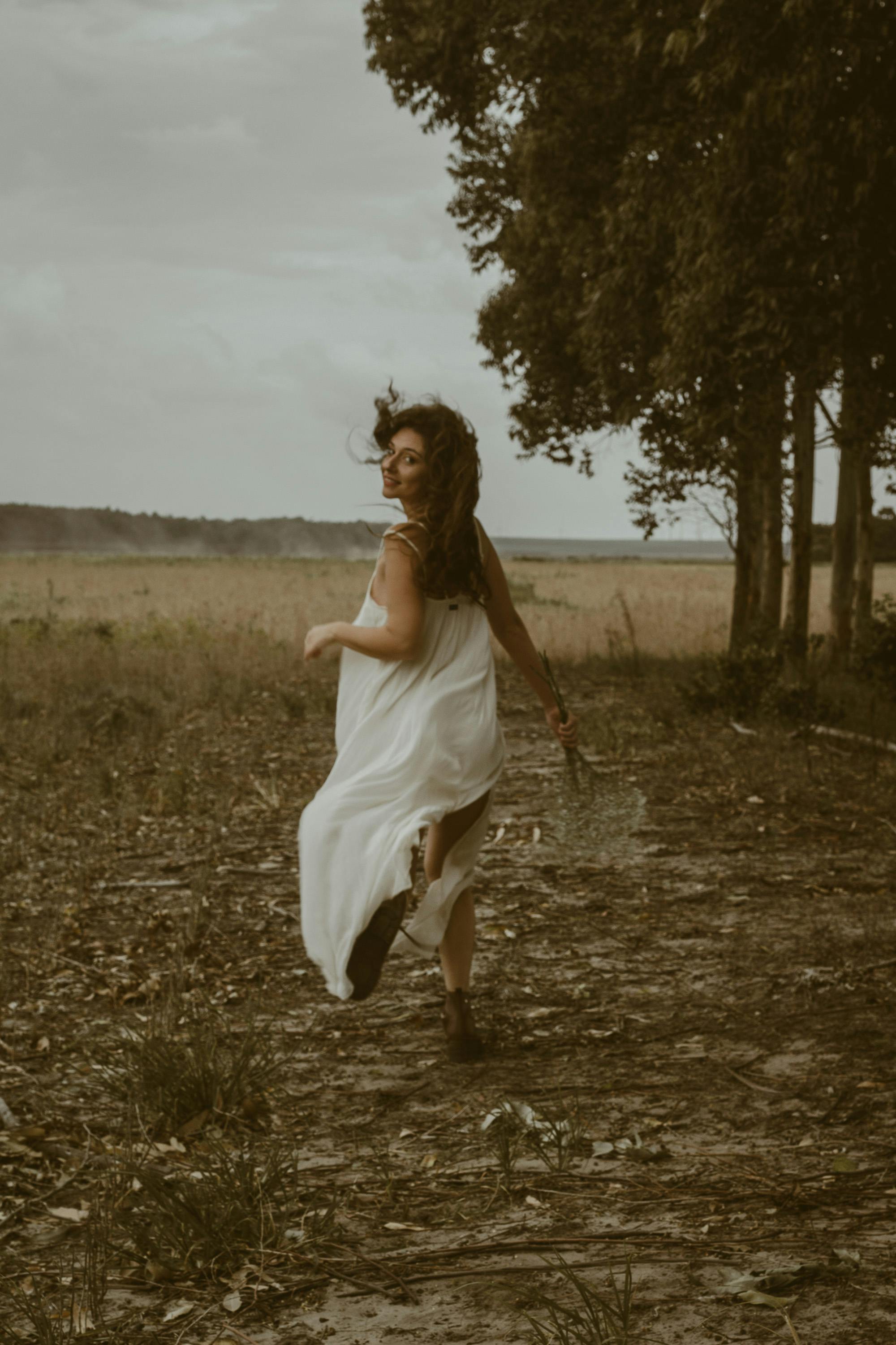 Woman in White Dress Running and Turning Back on Meadow · Free Stock Photo