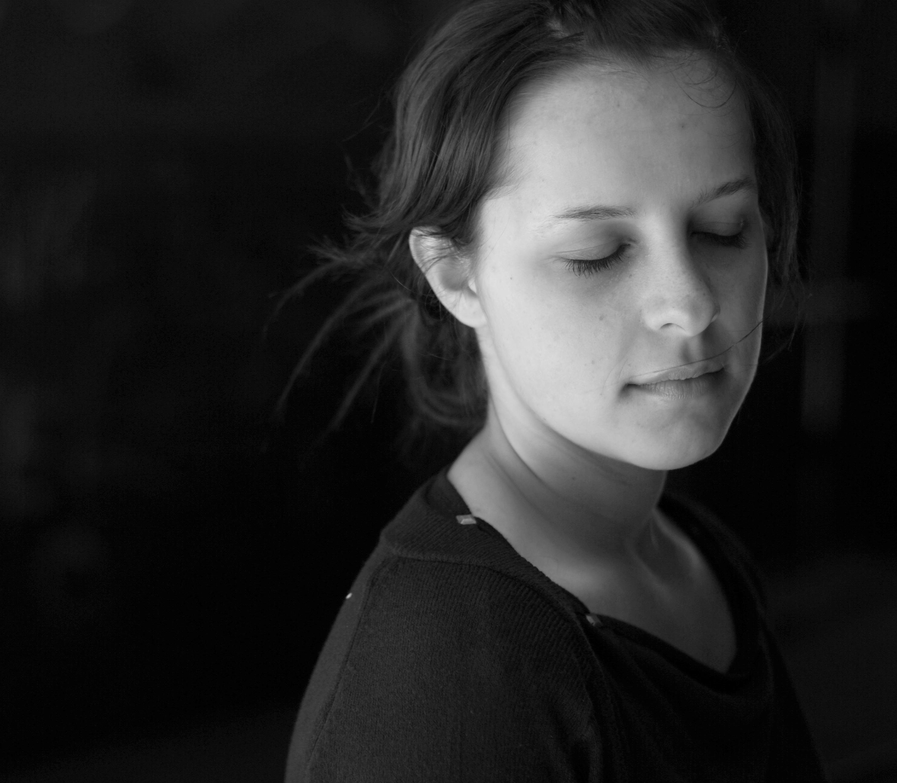 A woman with her eyes closed looking at something · Free Stock Photo