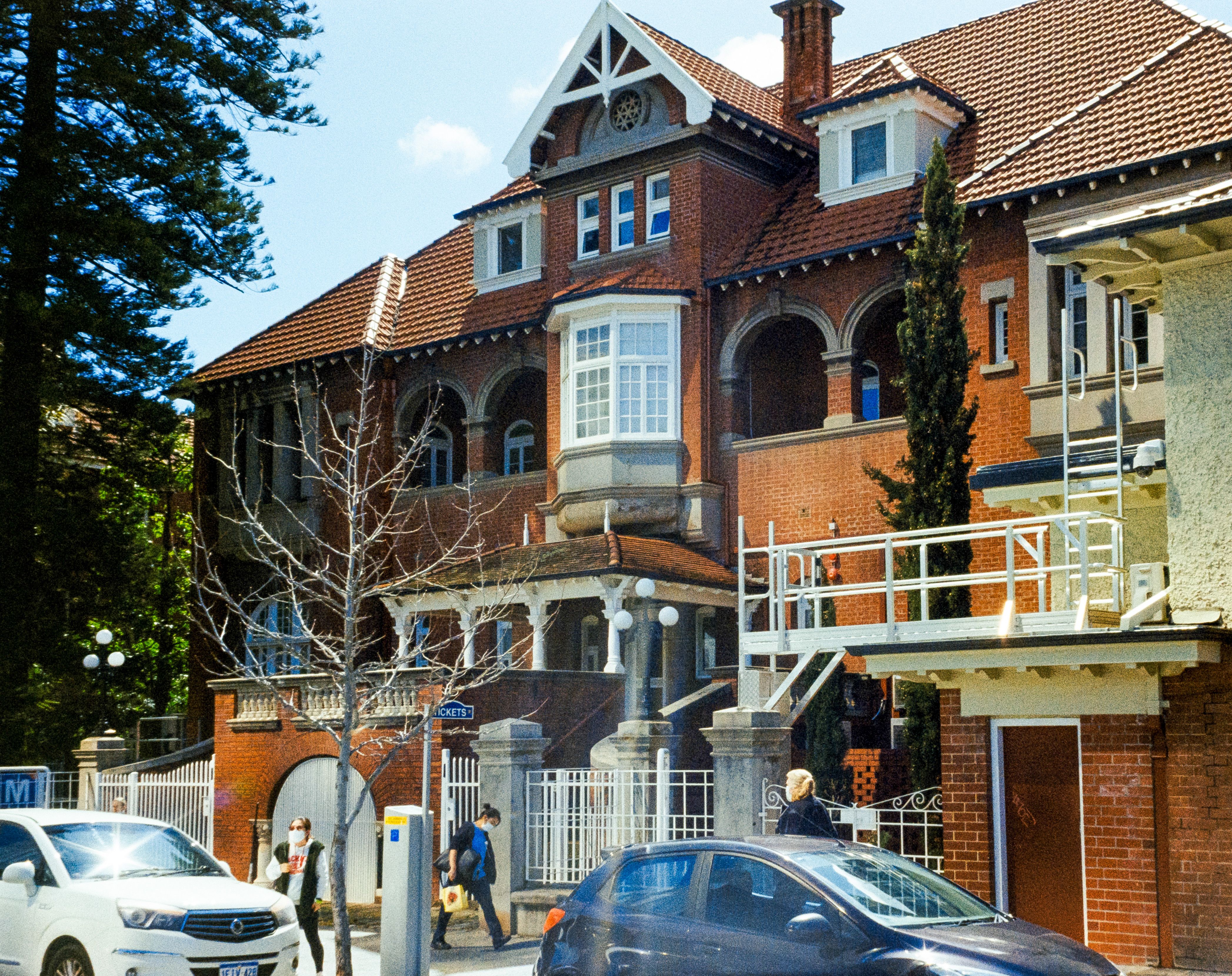 A large brick building with cars parked in front · Free Stock Photo