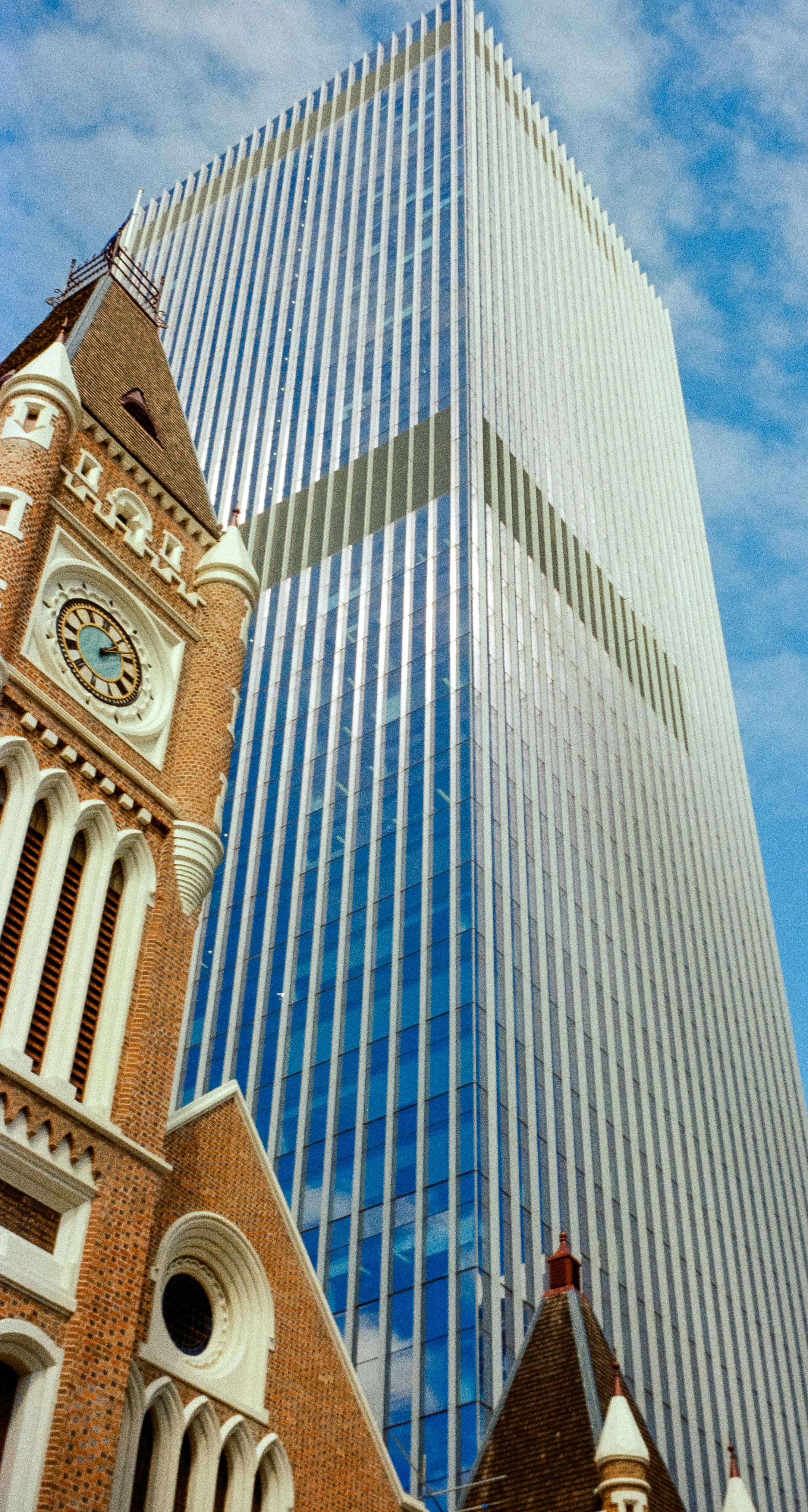 A tall building with a clock tower in front of it · Free Stock Photo