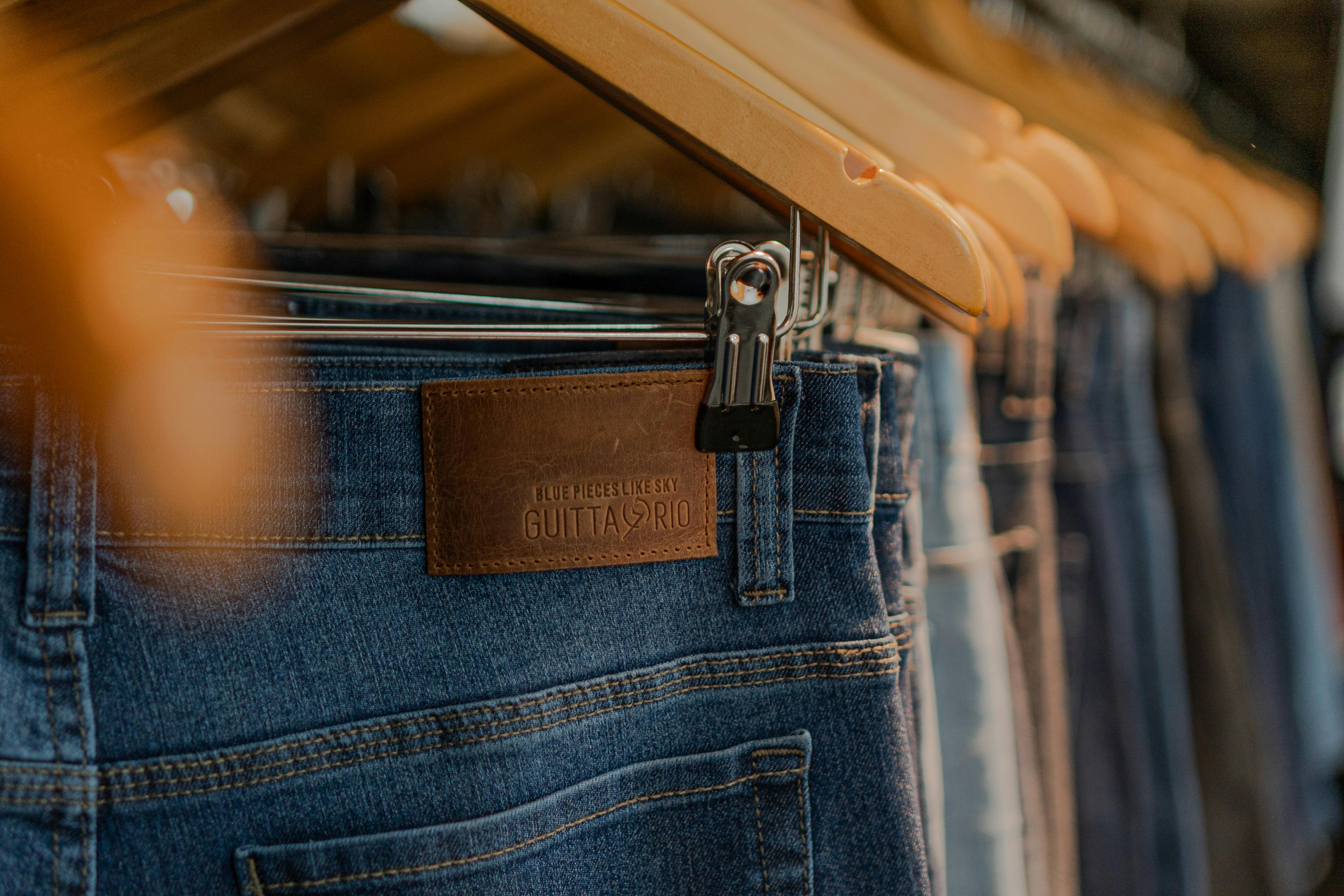 Close-Up Photo of Denim Jeans on a Clothing Rack · Free Stock Photo