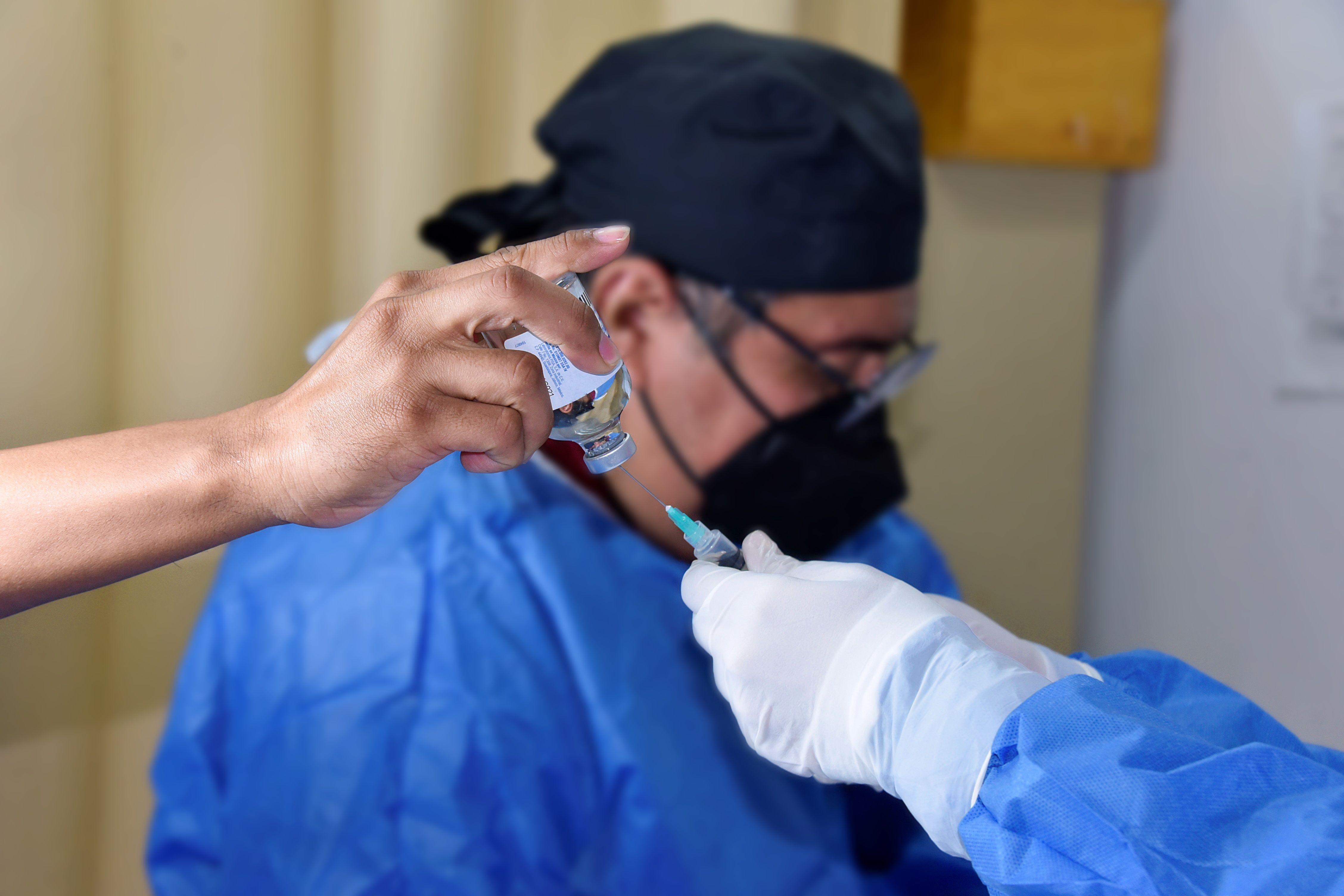 Hands Pouring Liquid from Bottle to Syringe with Man behind · Free ...