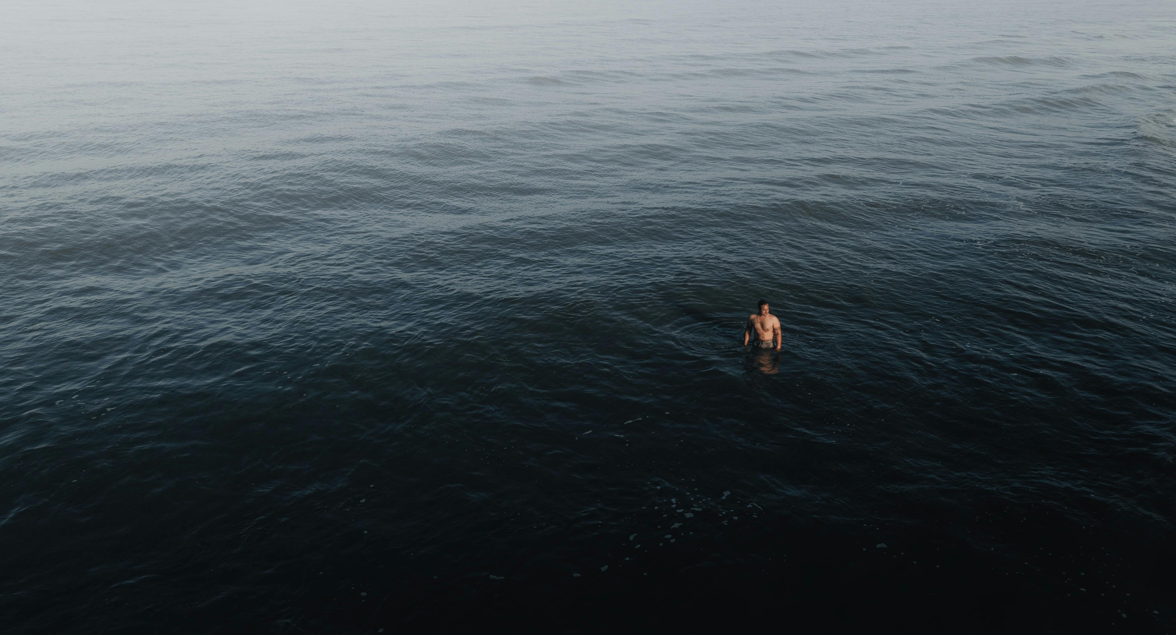 Man in Water on Shore · Free Stock Photo