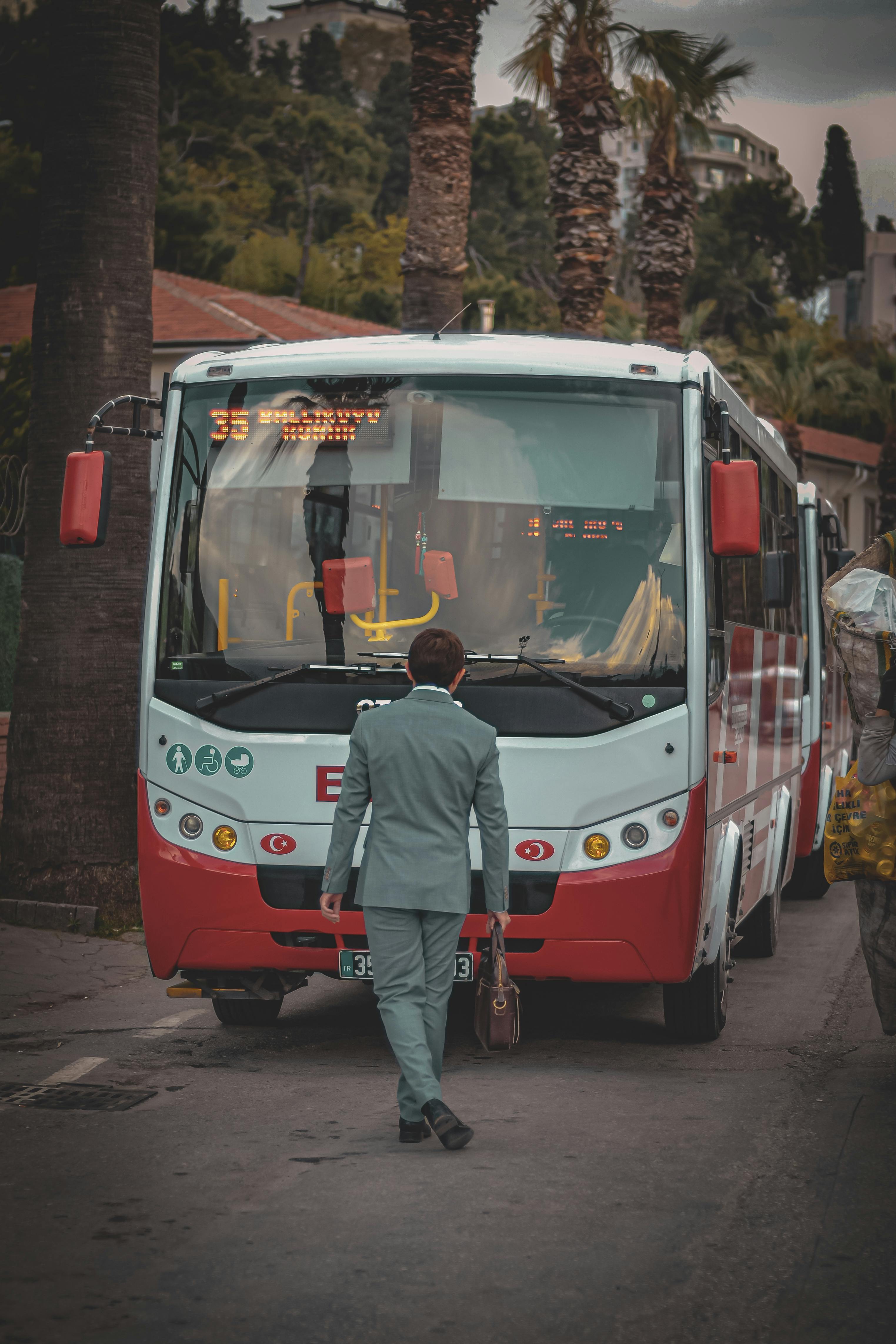 A Man in a Suit in Front of a Bus · Free Stock Photo