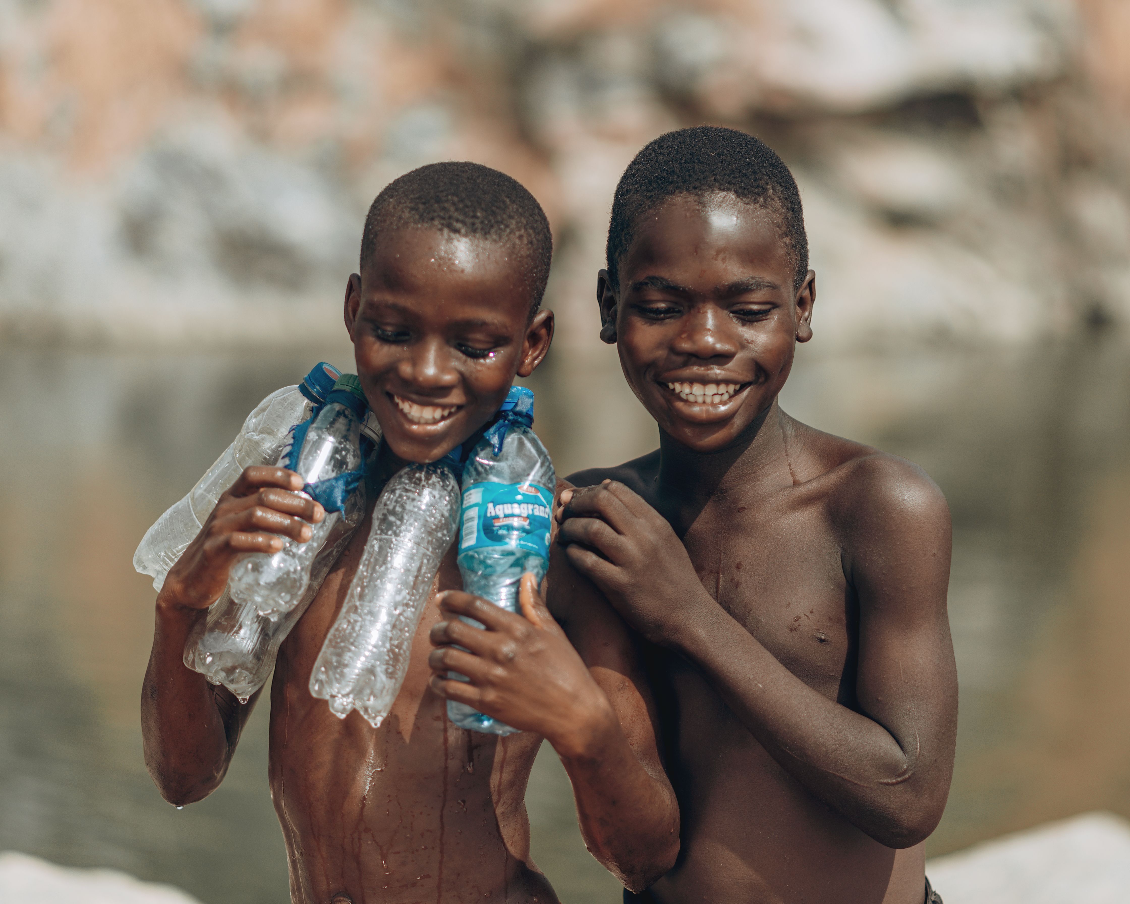 Smiling Boys Holding Bottles of Water · Free Stock Photo
