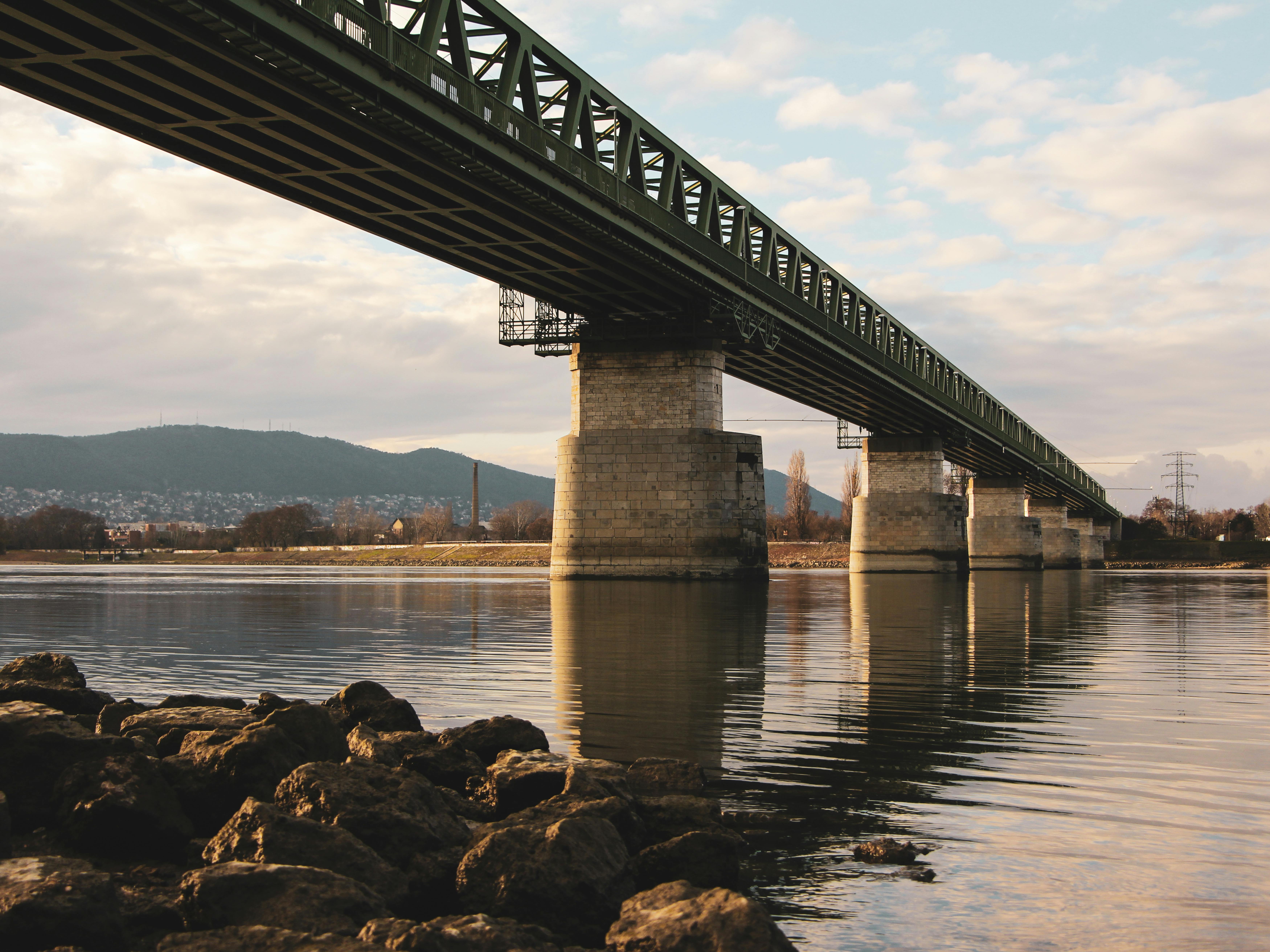 Grey Concrete Bridge Above Water Under Blue Sky · Free Stock Photo