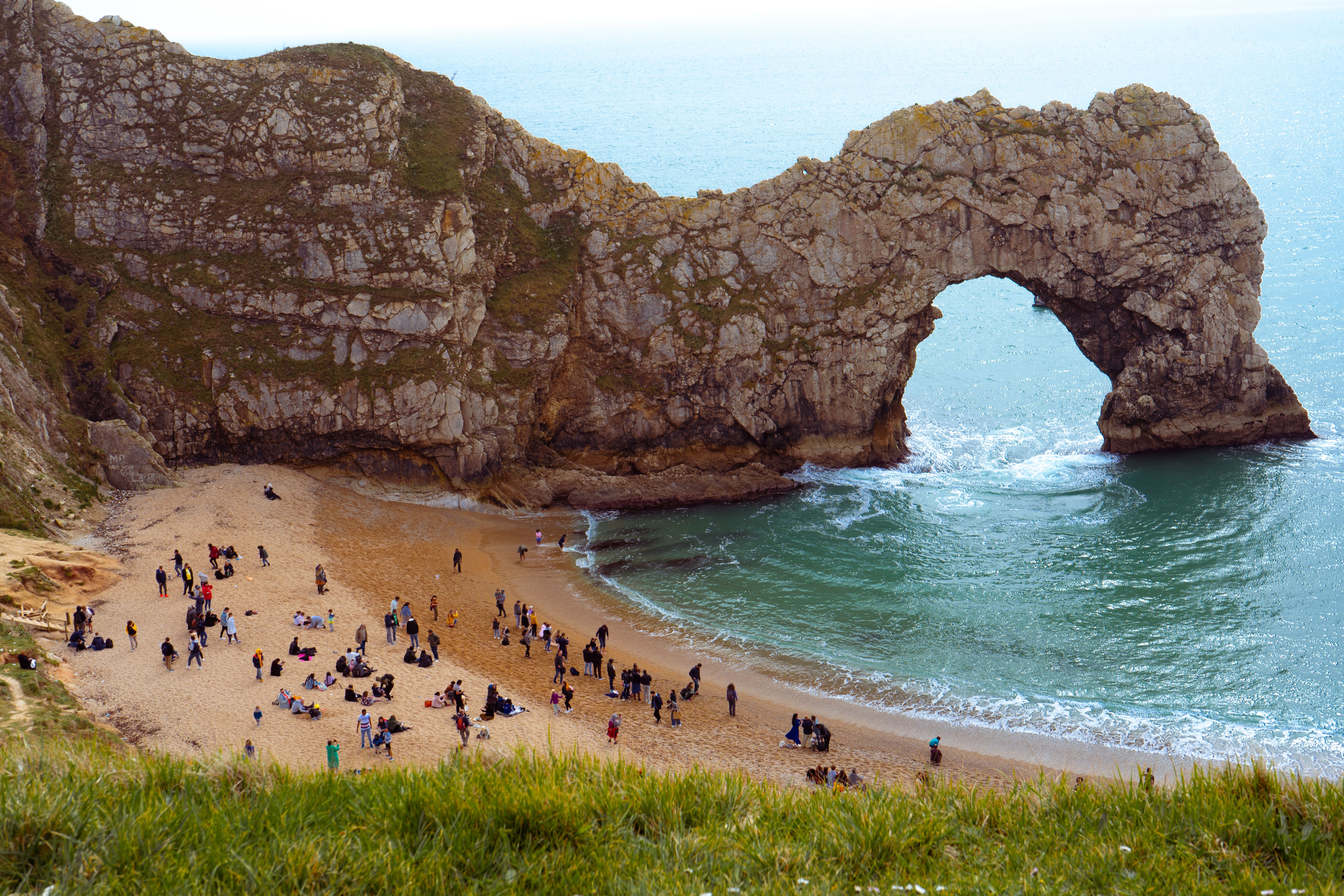 People on Beach near Natural Arch in Dorset · Free Stock Photo