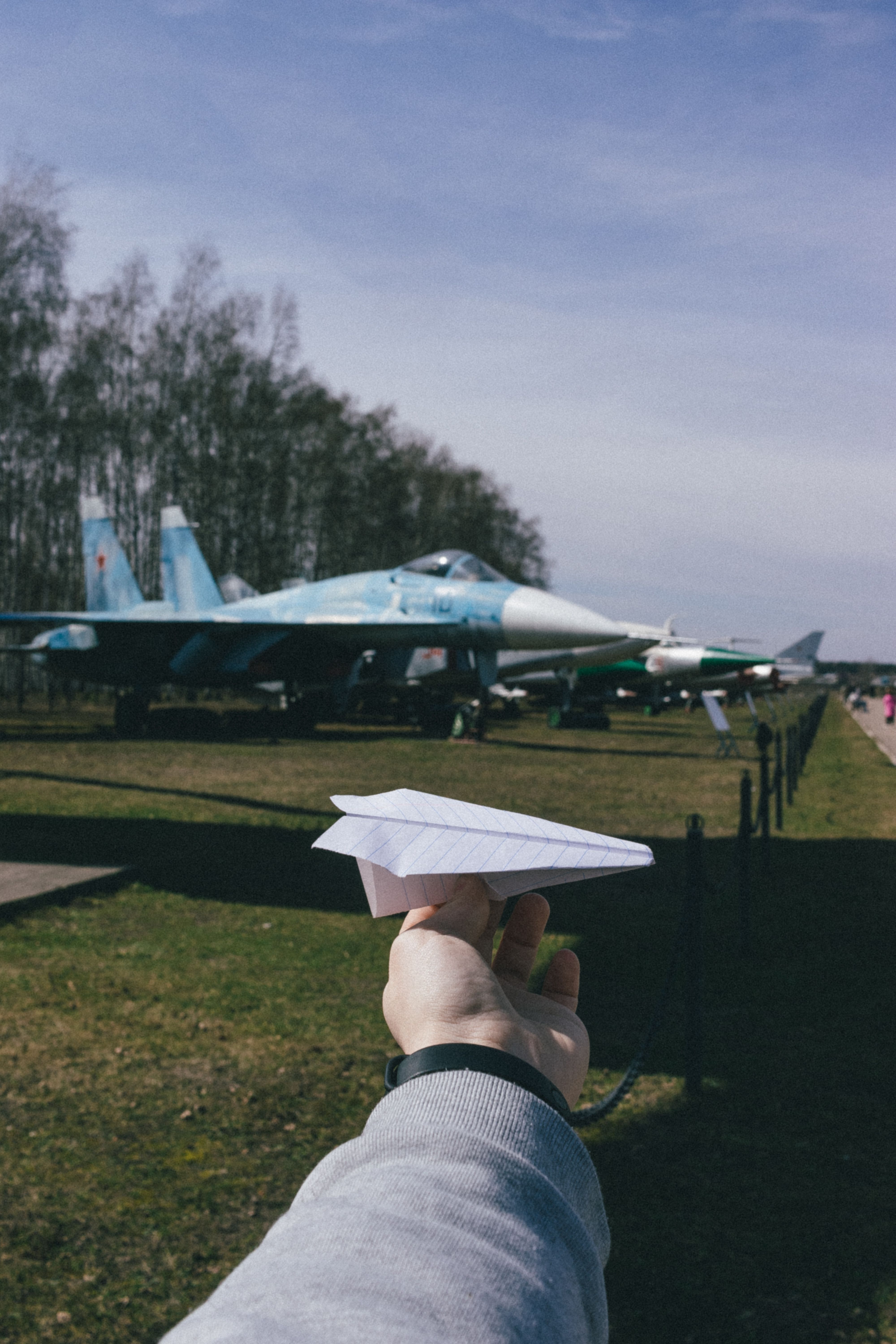 Photo of a Hand Holding a Paper Plane in Front of a Fighter · Free ...