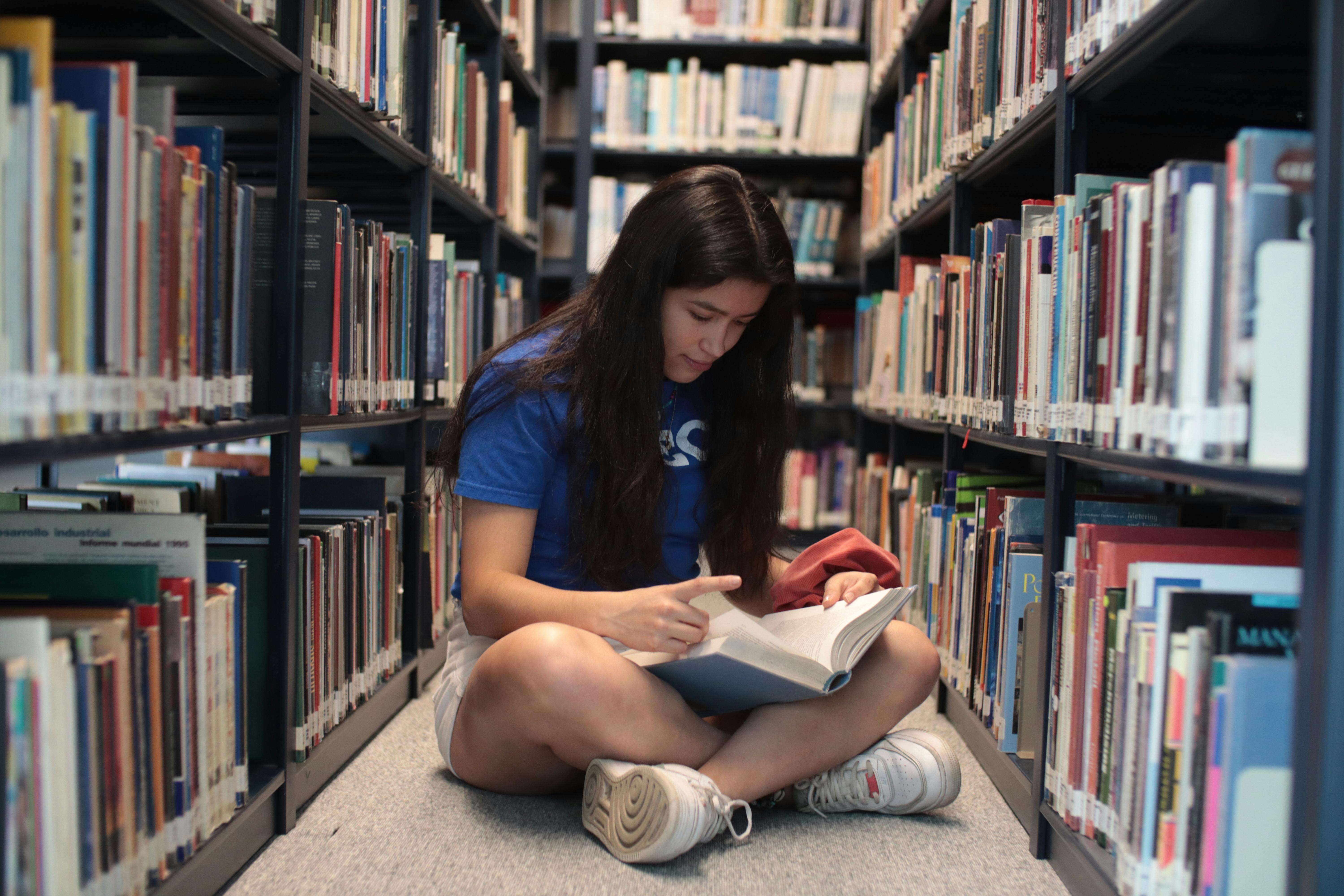 Woman Sitting and Reading at Library · Free Stock Photo