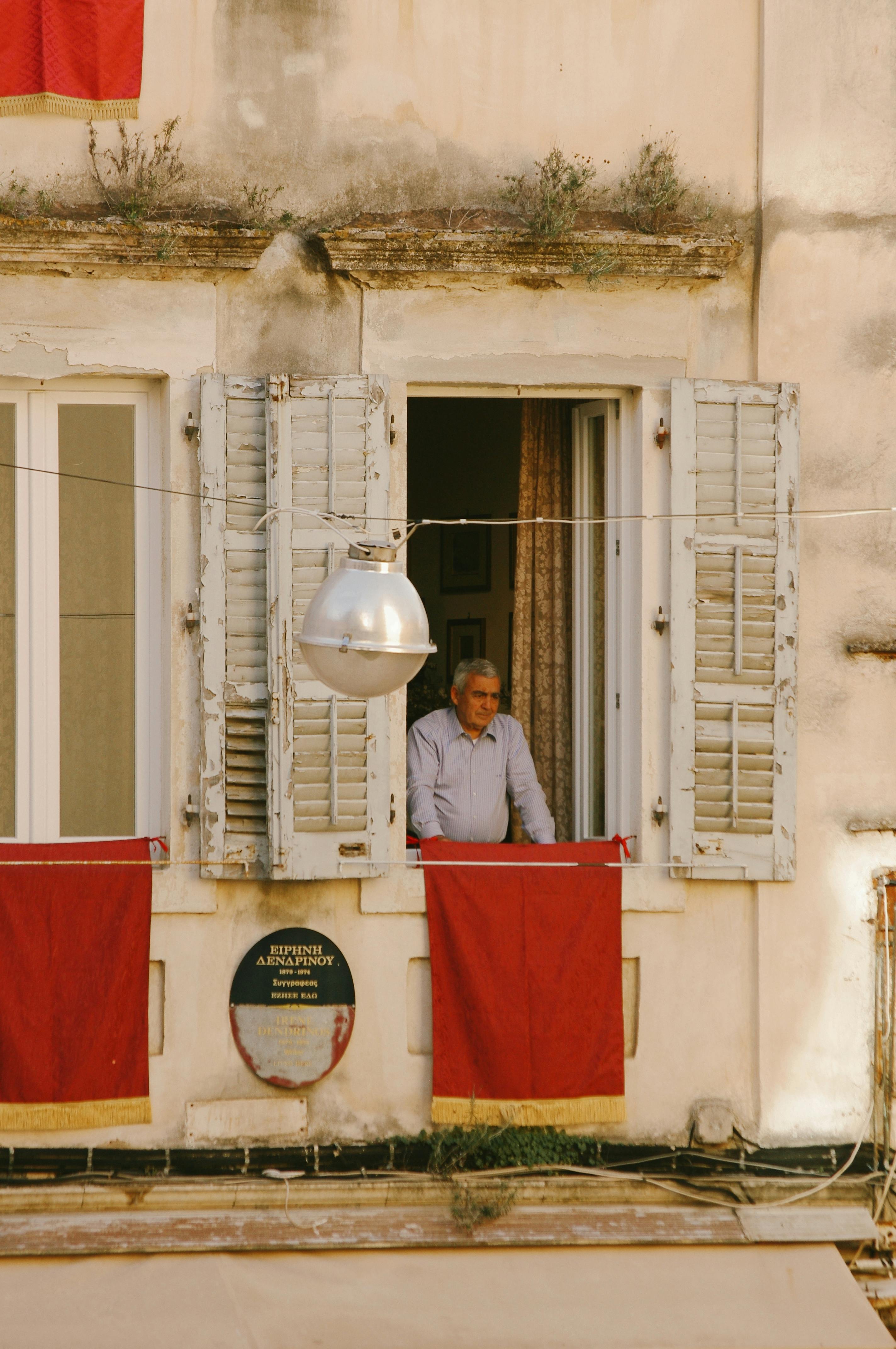A Man Standing in the Window of a Traditional Building with Wooden ...