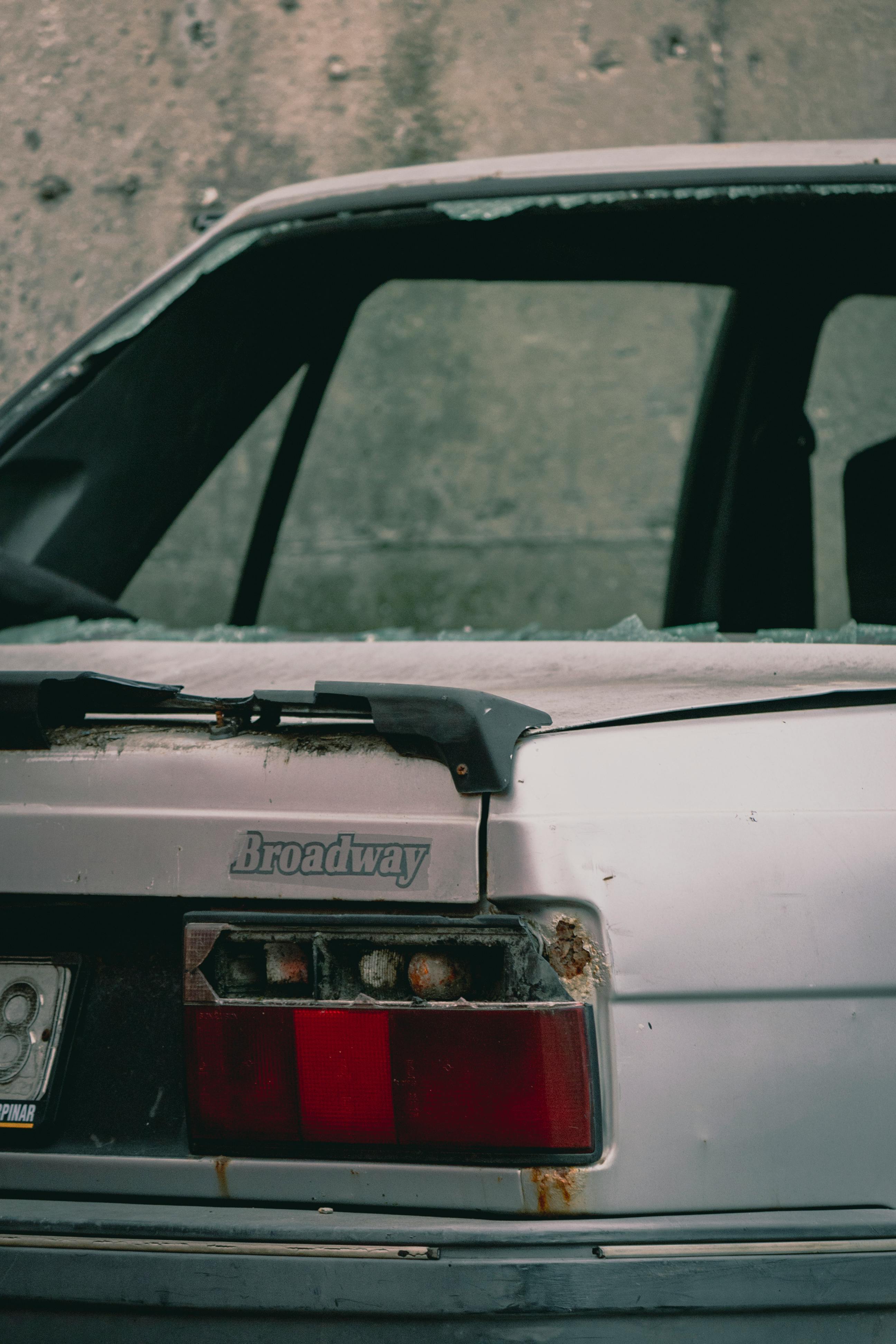 A car with a broken window and a broken tail light · Free Stock Photo