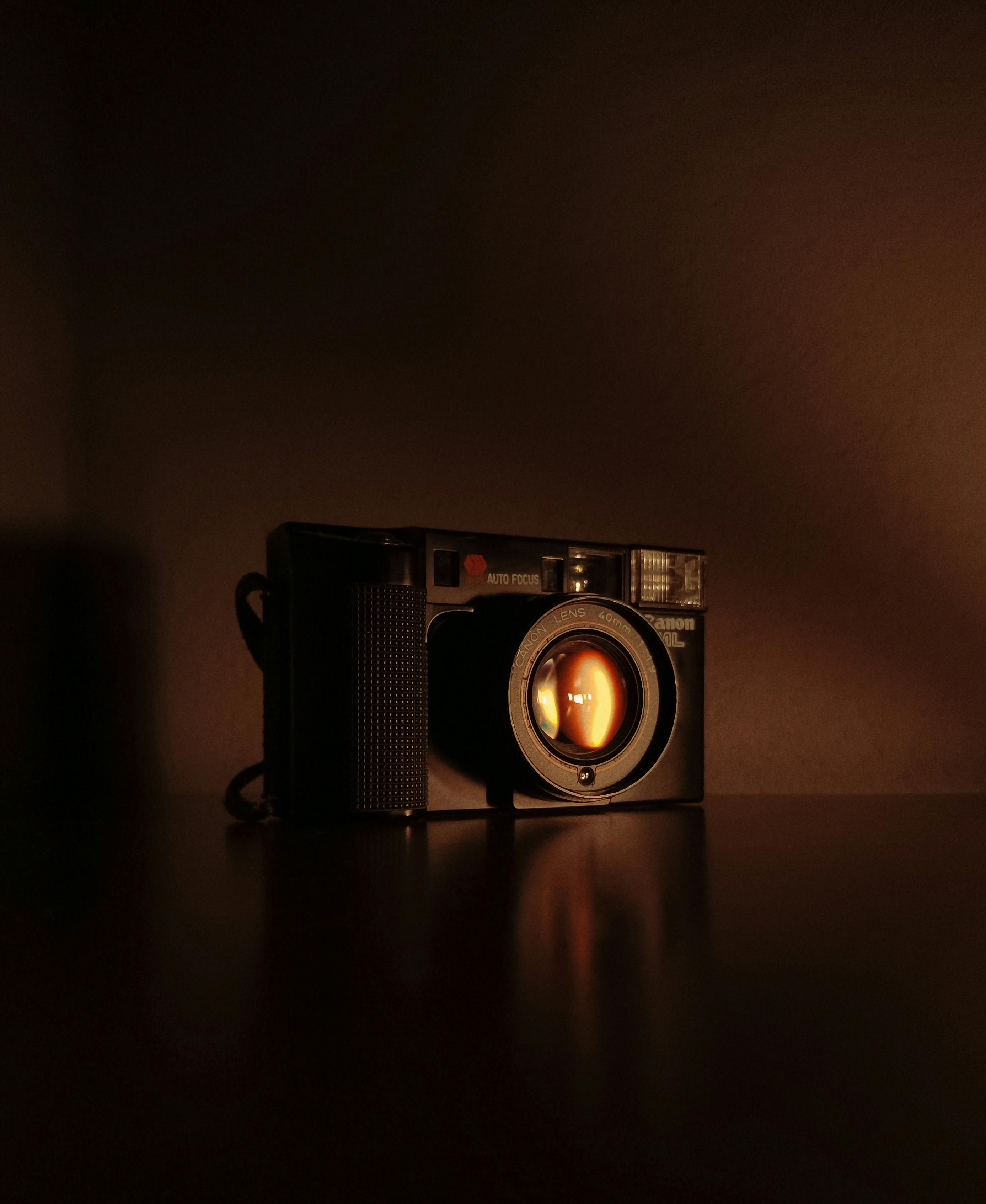 A camera with a light on it in the dark · Free Stock Photo