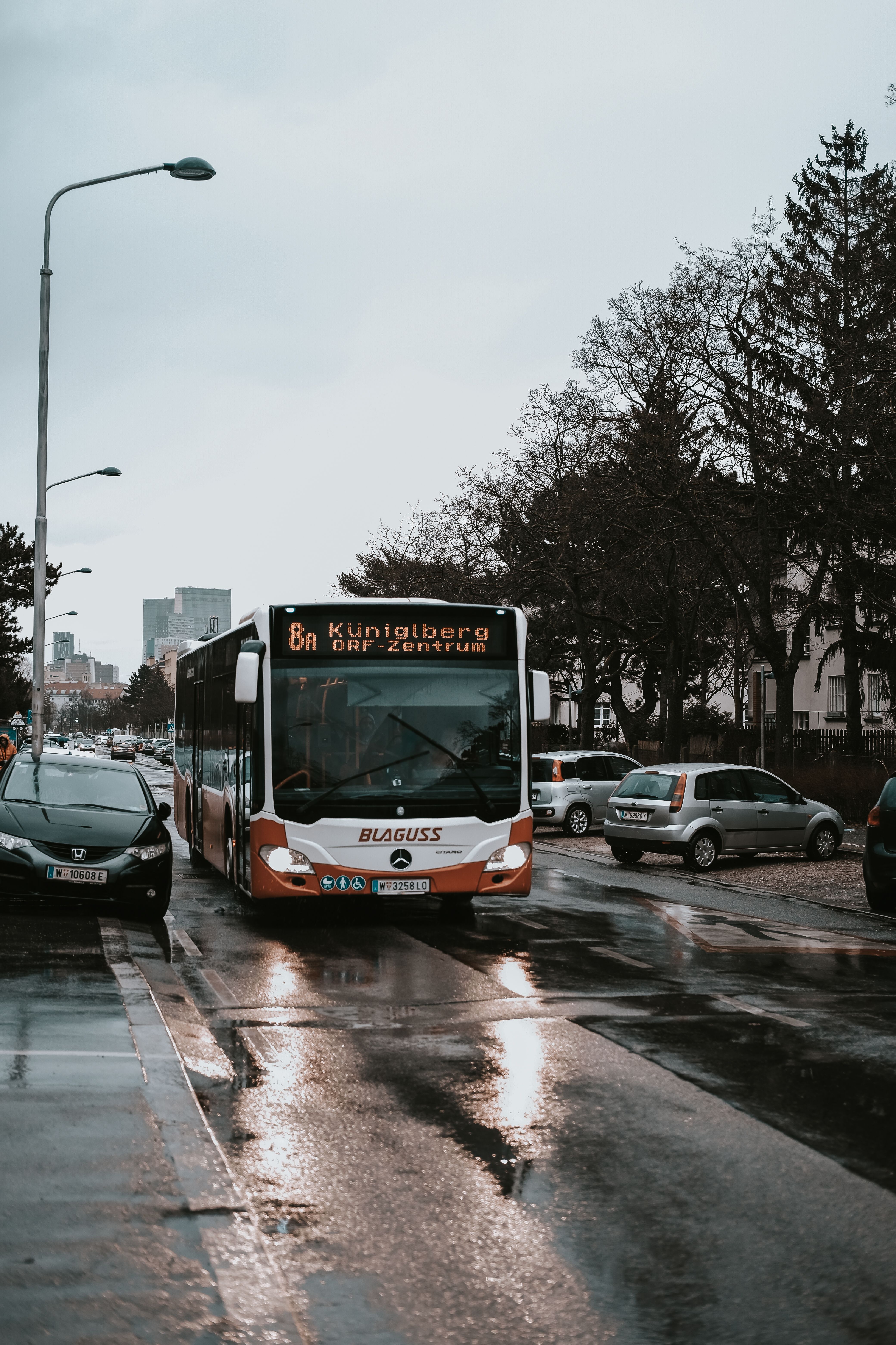 A bus driving down a wet street · Free Stock Photo
