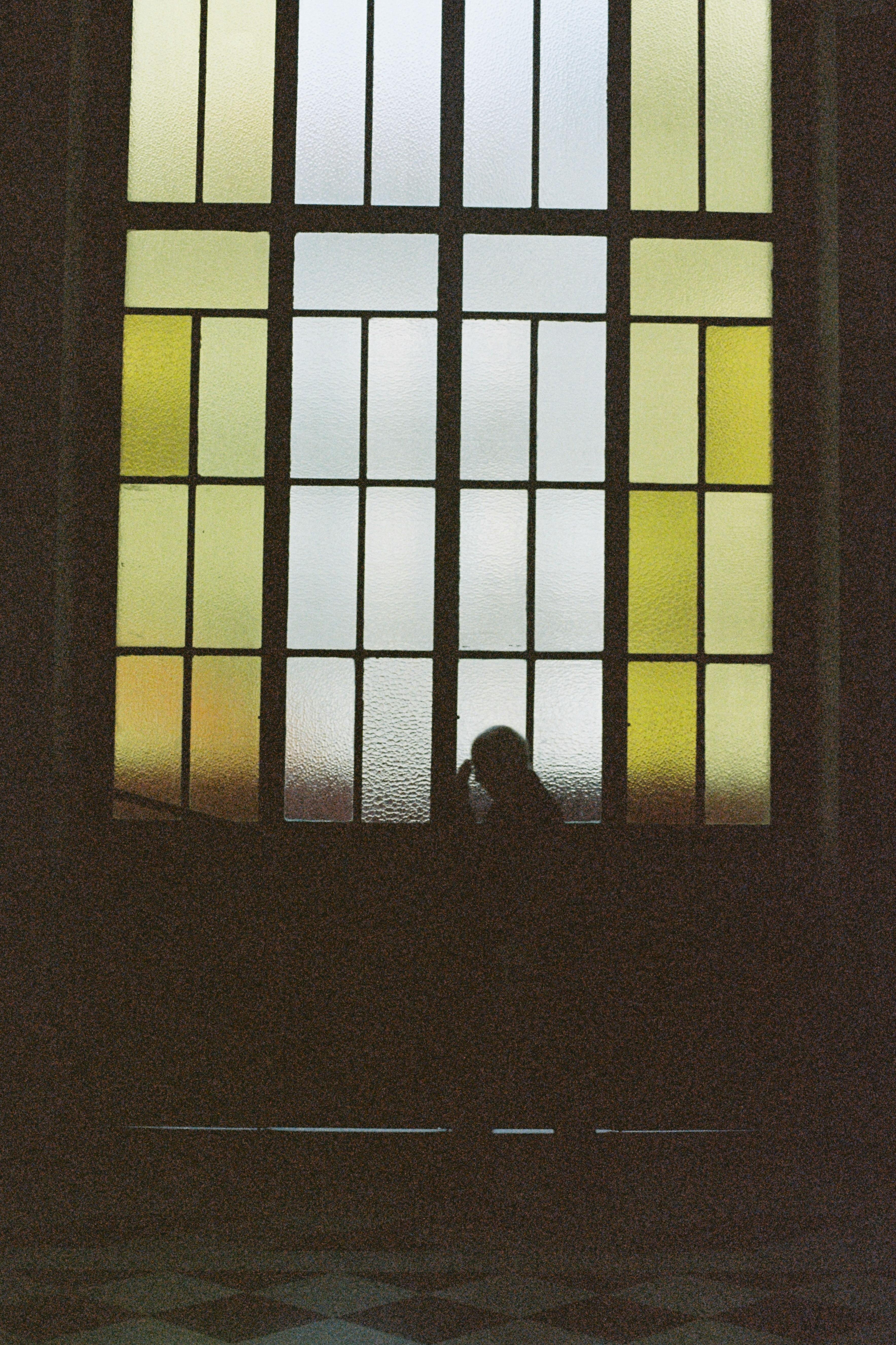 A person standing in front of a window with stained glass · Free Stock ...