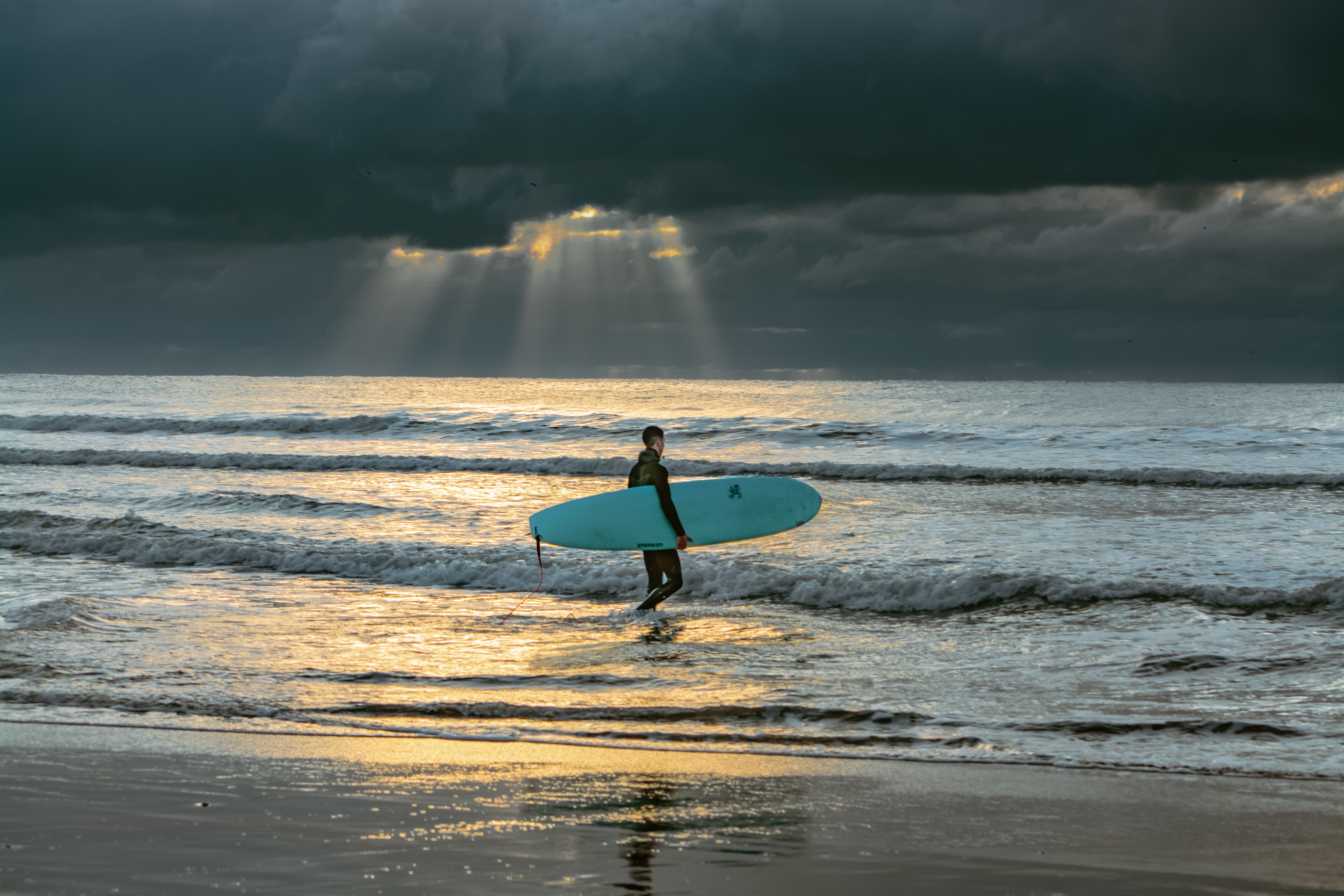 Surfer in Sea under Storm Clouds · Free Stock Photo