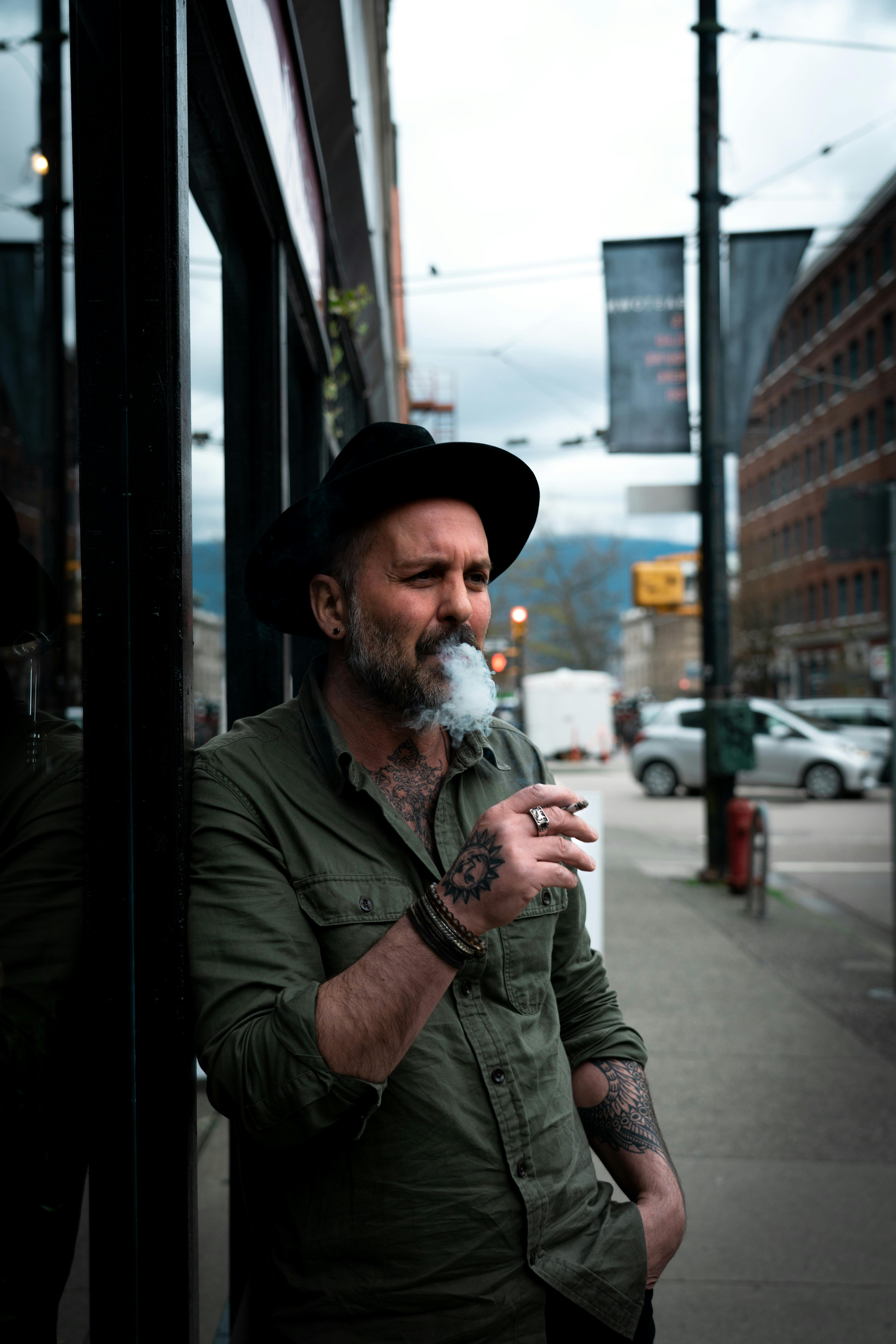 Man Smoking Marijuana on Sidewalk · Free Stock Photo