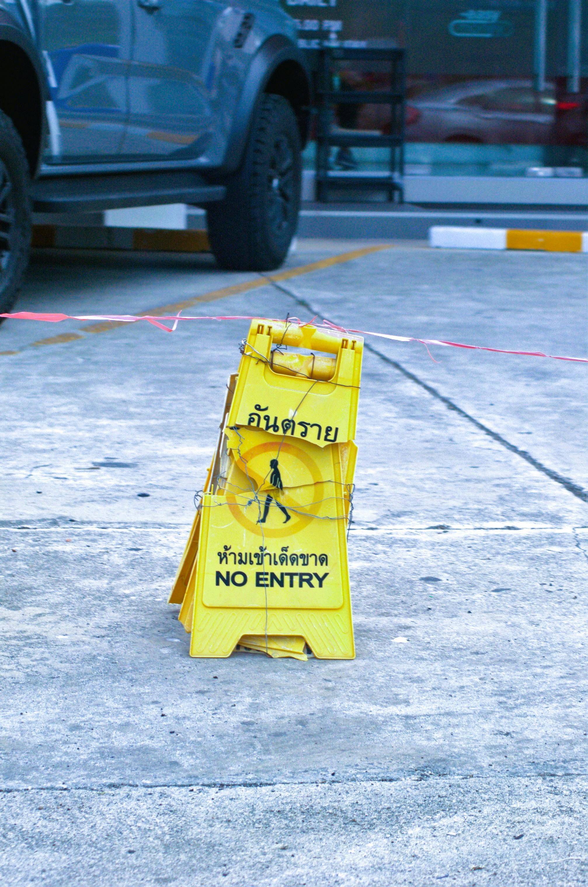Broken Caution Yellow Sign on Pavement · Free Stock Photo